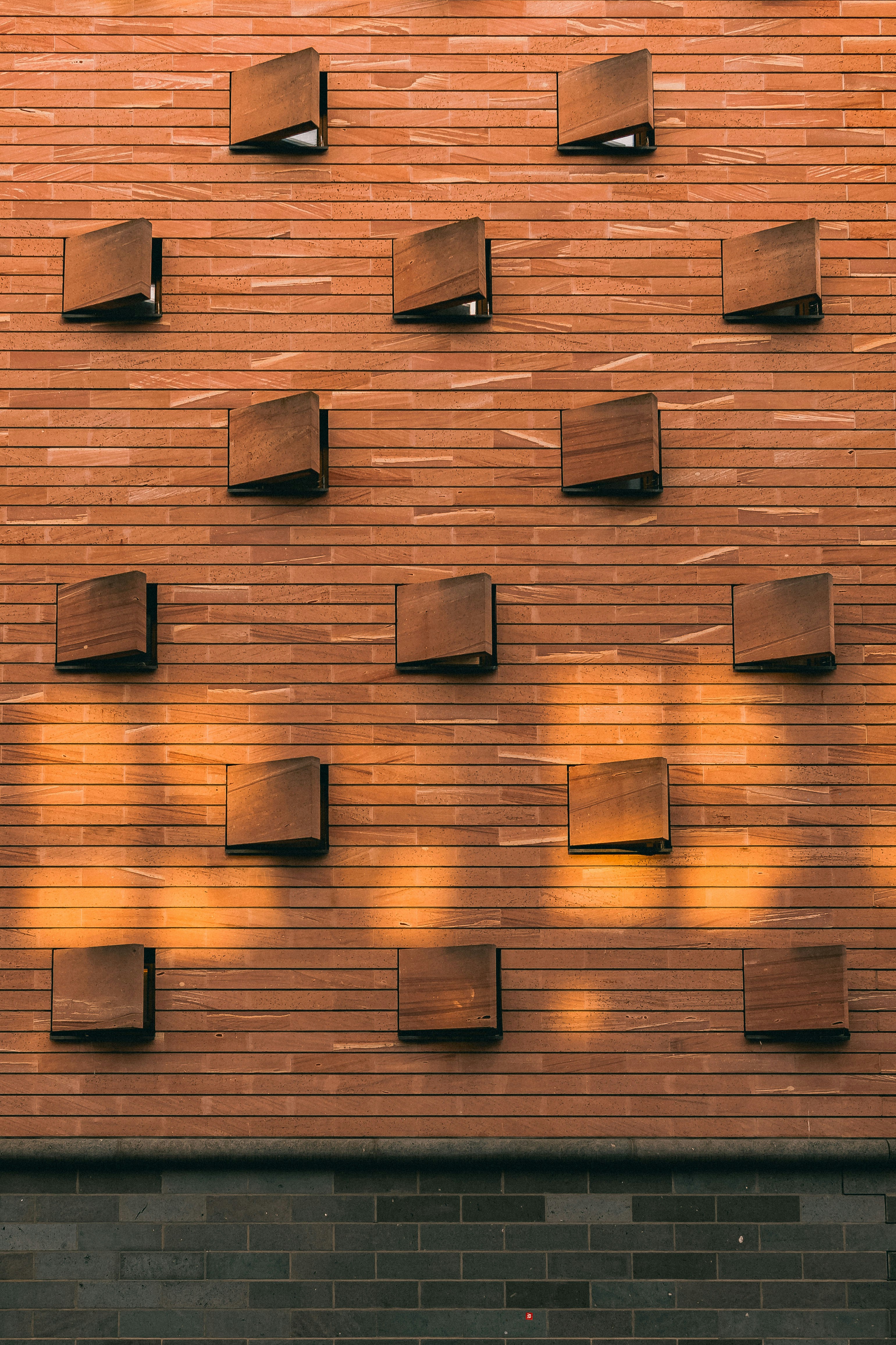 Brick wall with protruding vents bathed in warm afternoon light