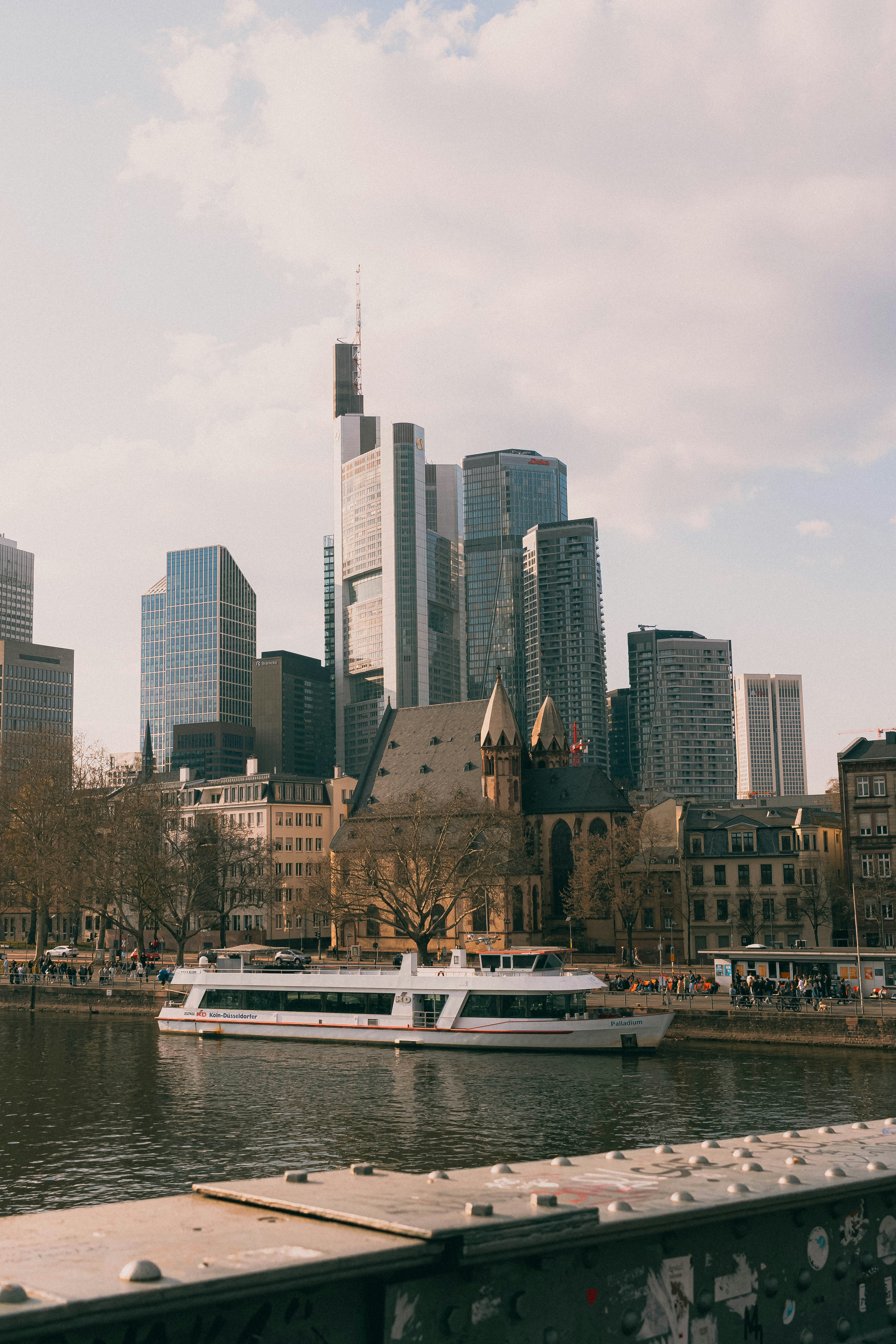 City at Dusk: A Riverbank Between Old Stone and Glass Skies