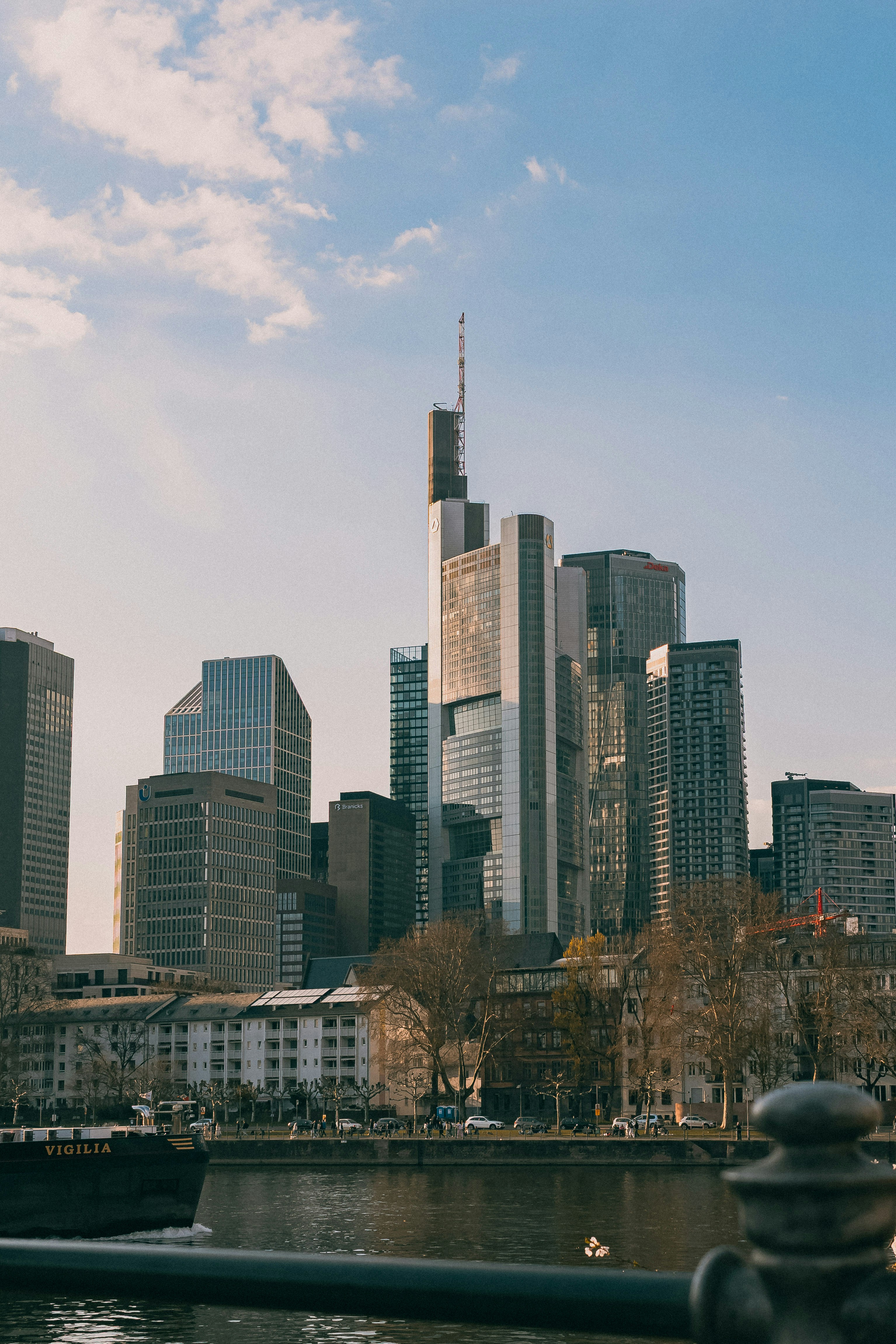 Urban Skyline at Rivershore: Sunlit Towers and Quiet Boats