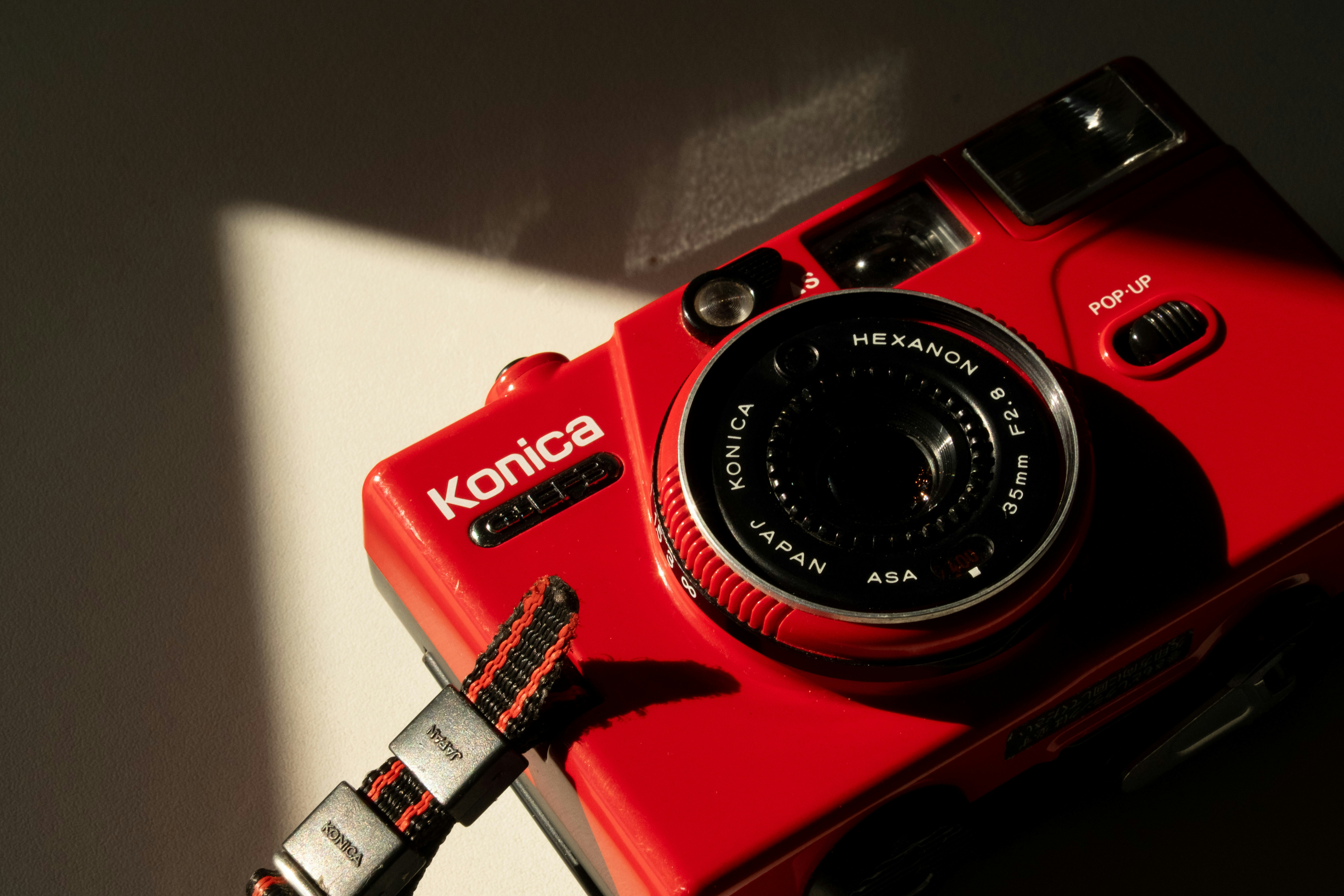 Crimson Konica: a retro compact in dramatic shadow