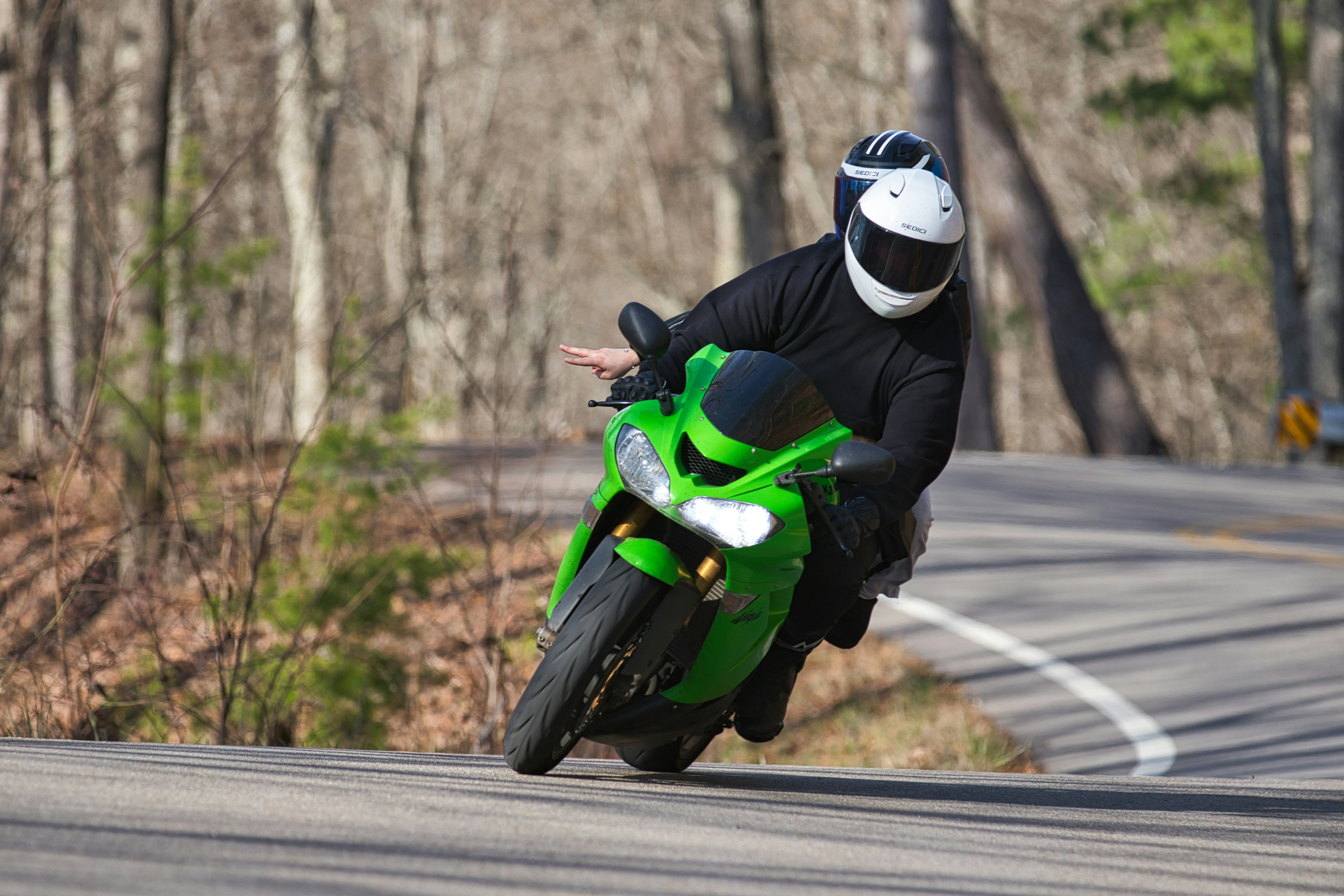 Green Thunder on the Curve: Rider Leaning Into the Turn