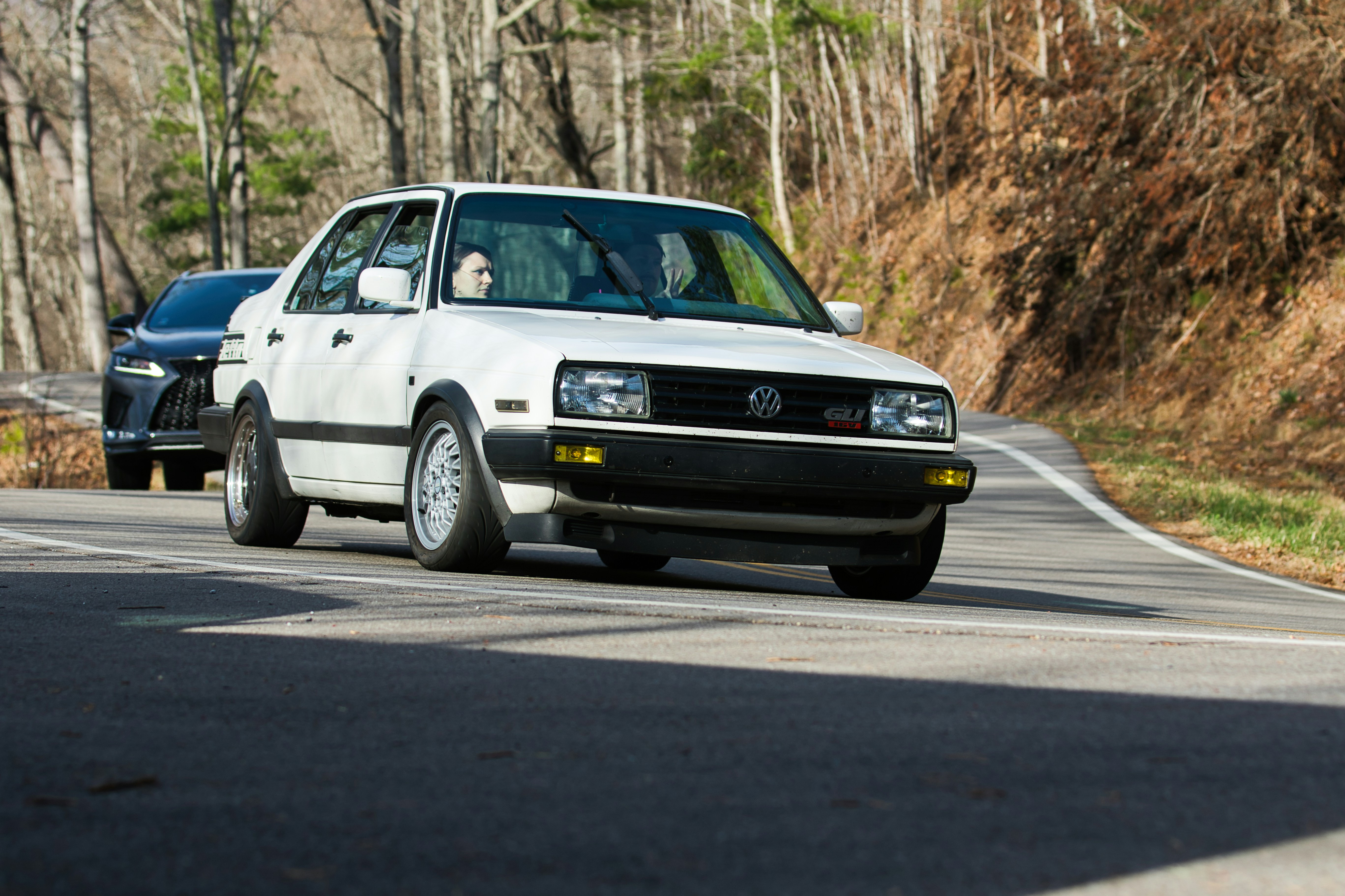 White VW Surges Toward the Bend on a Quiet Mountain Road