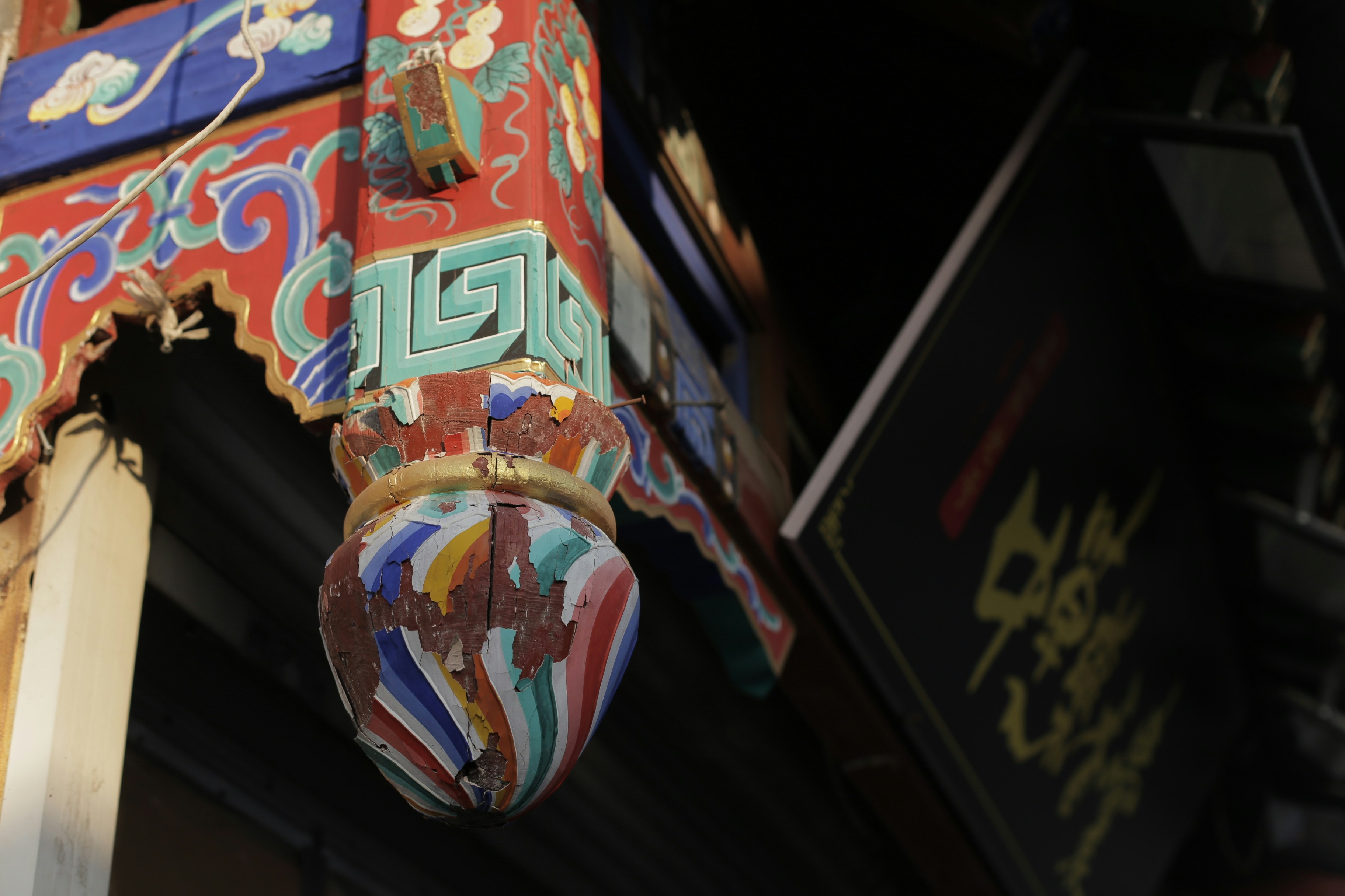 Palette of Lanterns: A Striking Painted Lantern Hangs Above a Decorated Arch