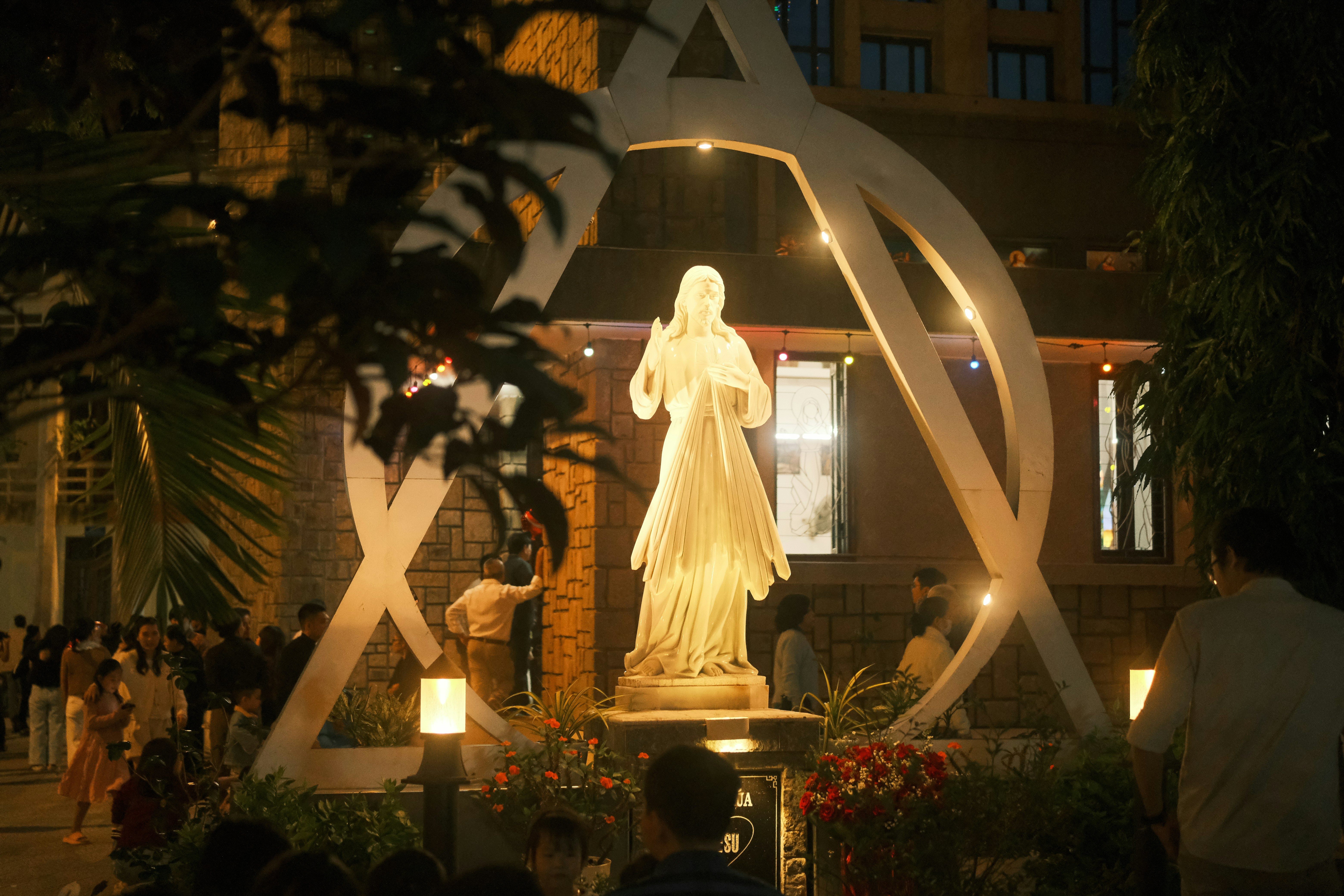 Illuminated Statue Under Circular Frame in Night Plaza