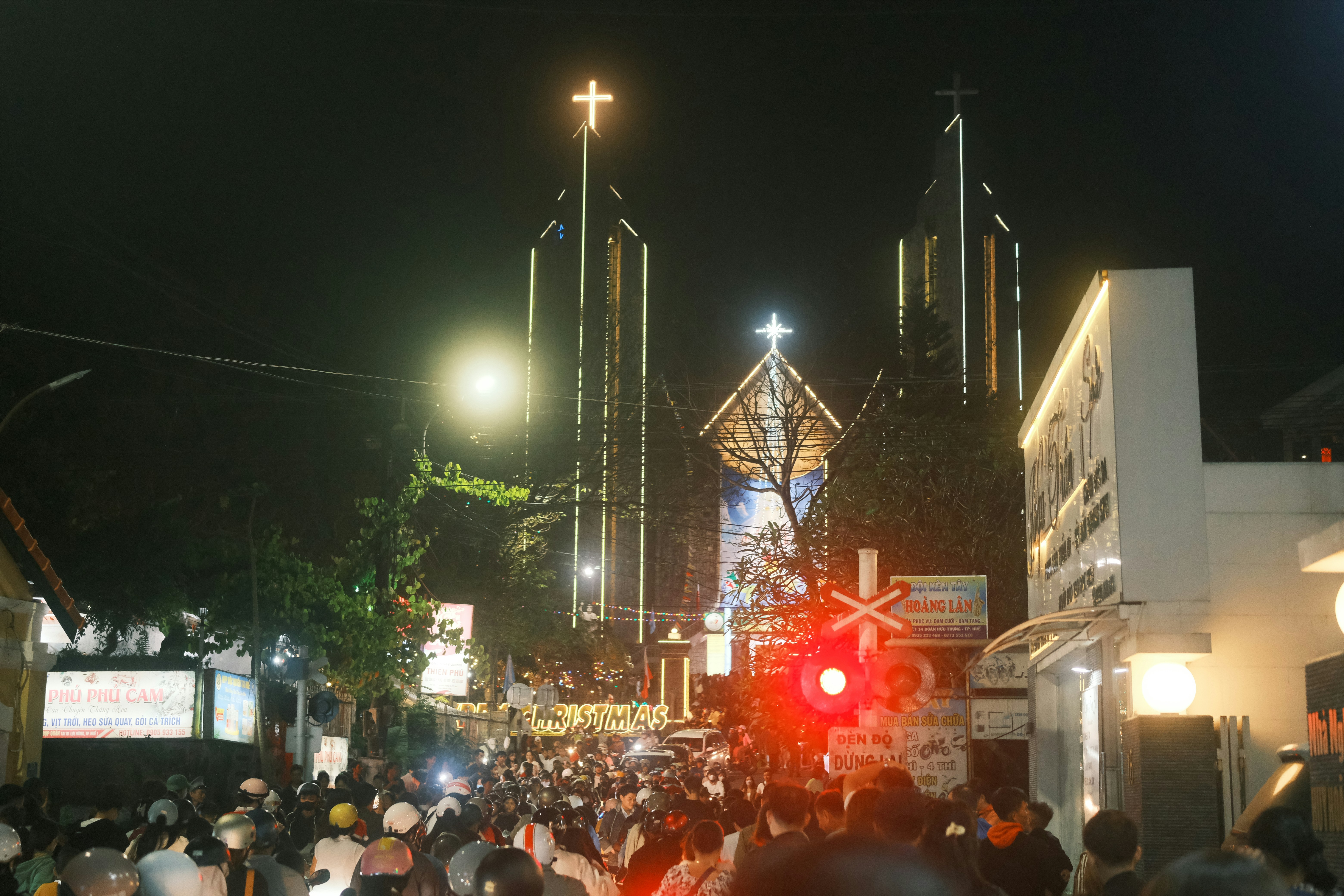 Neon Christmas Eve: A Cathedral of Lights Over a Crowded Street