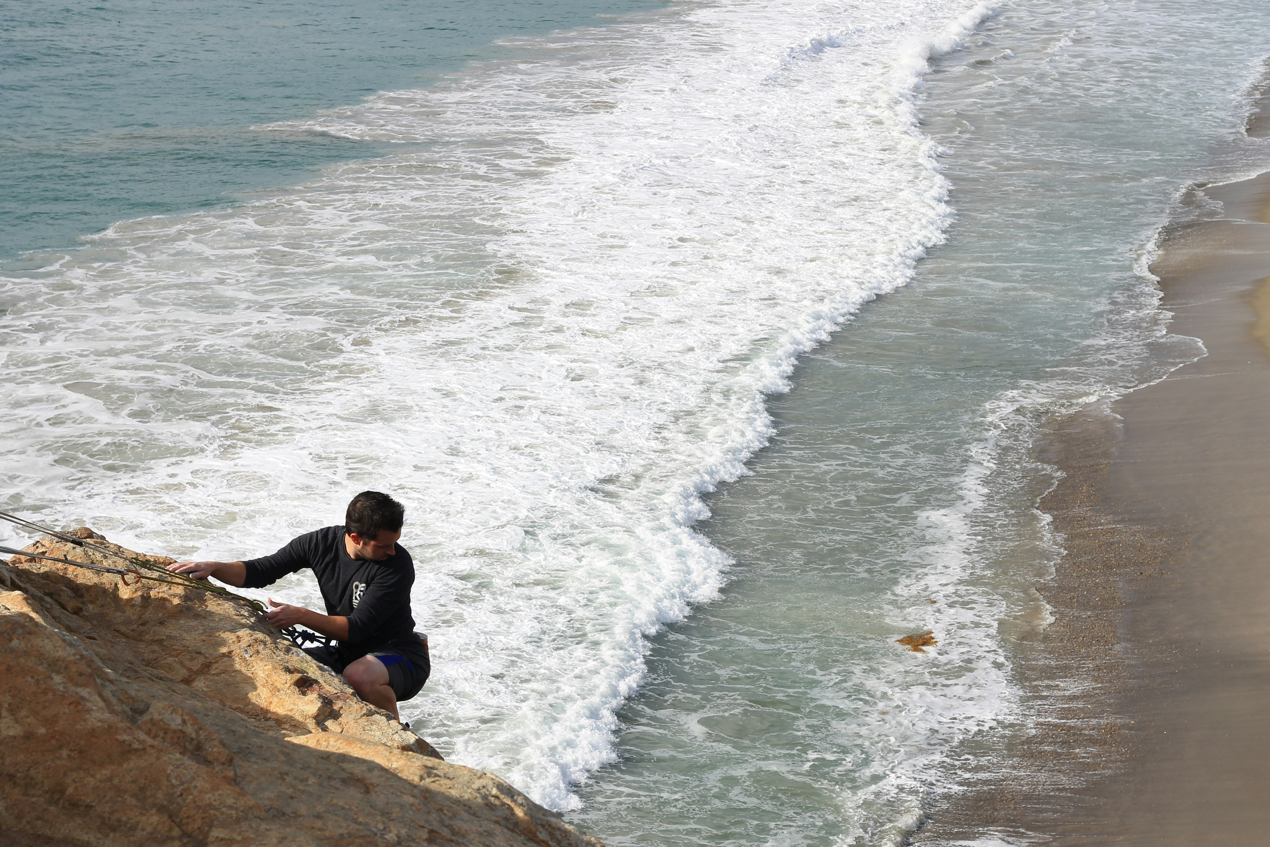 Crimson Peak: Climber On the Cliff Beside Lapping Tide