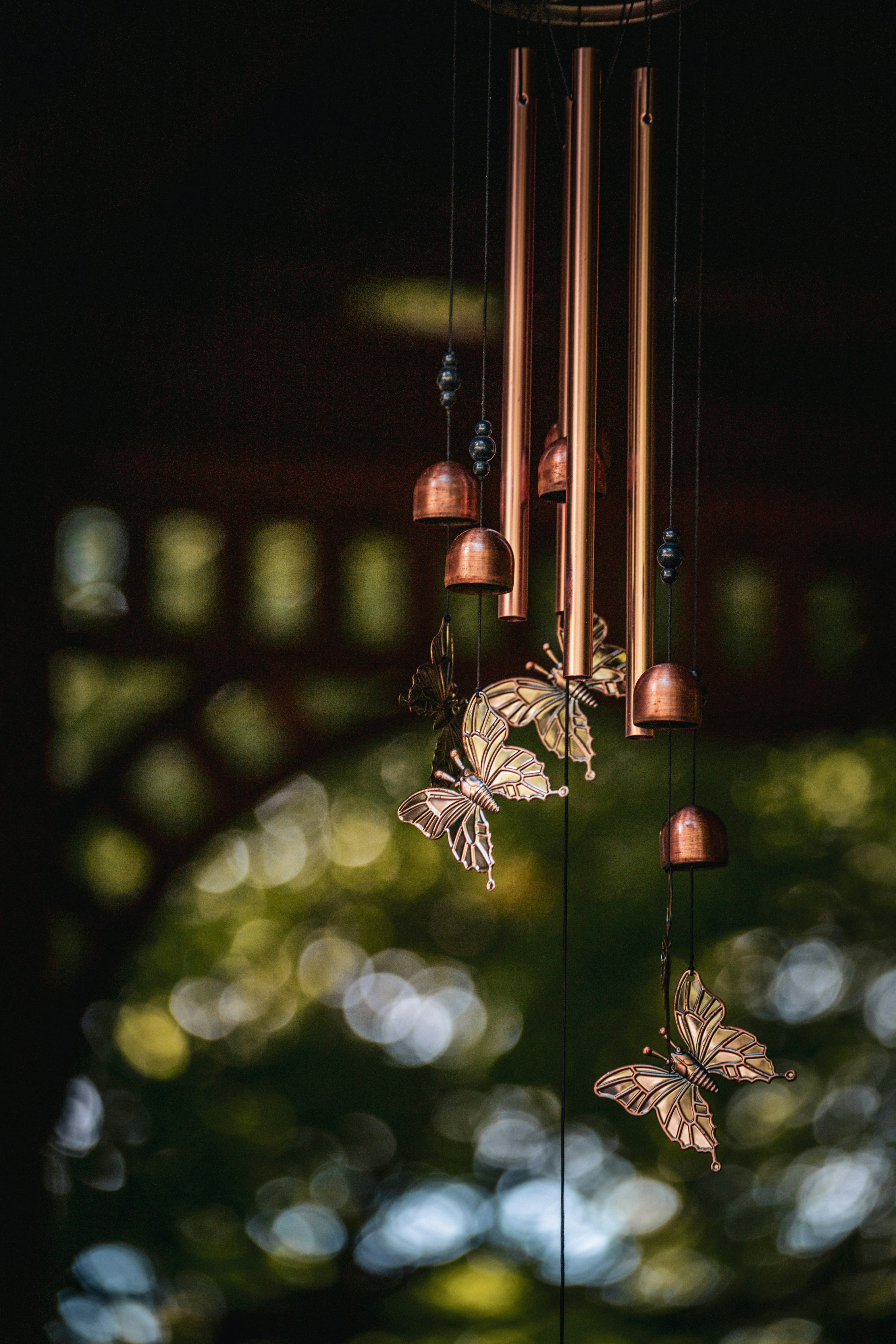 Copper bells and delicate butterfly silhouettes in a sunlit garden