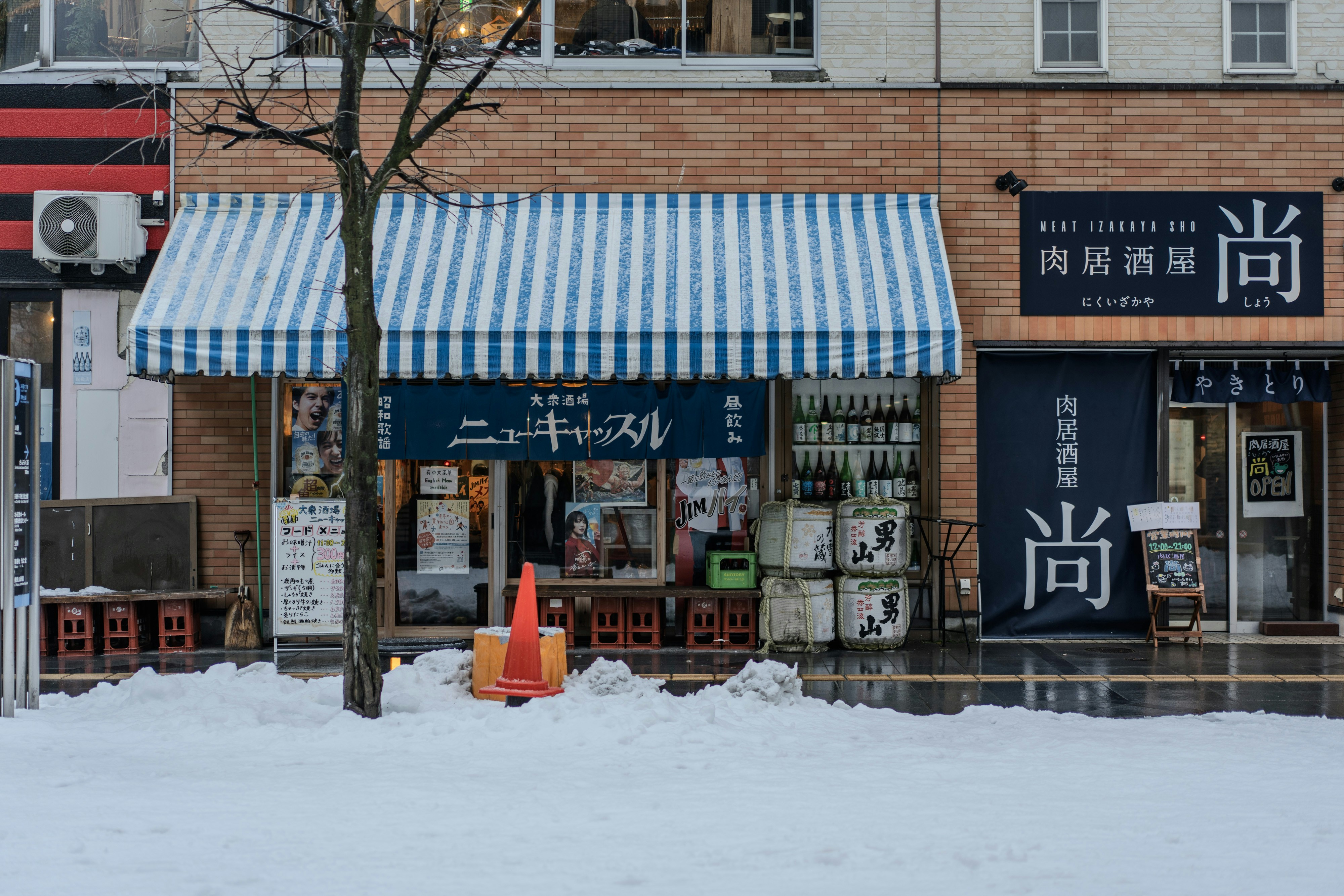 Snowfront storefronts under blue-striped awning