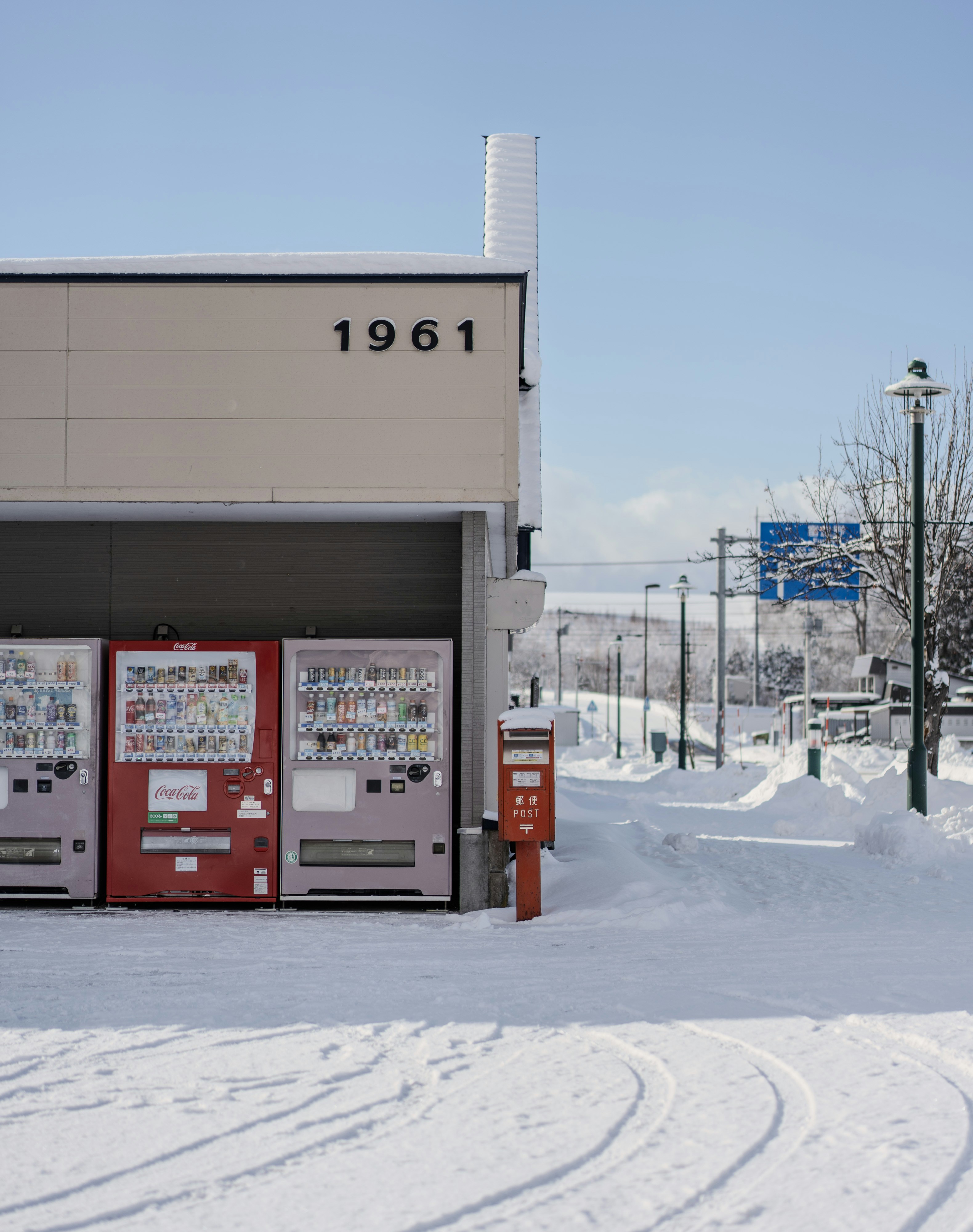 Snowbound Convenience: Vending Machines and Mailbox Stand Against a Quiet Winter Street