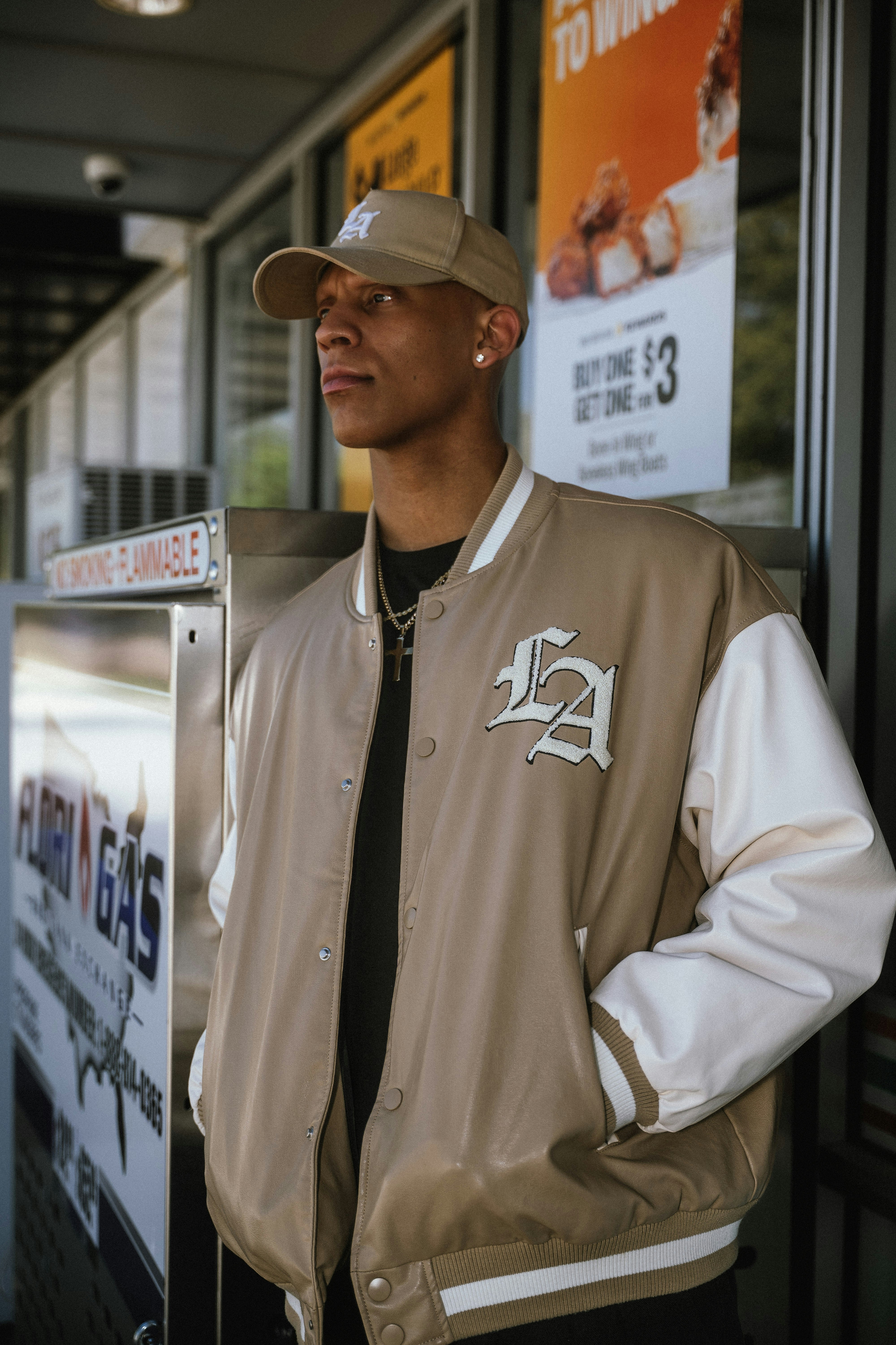 Portrait at the Storefront: A Calm Gaze in a Tan Letterman Jacket