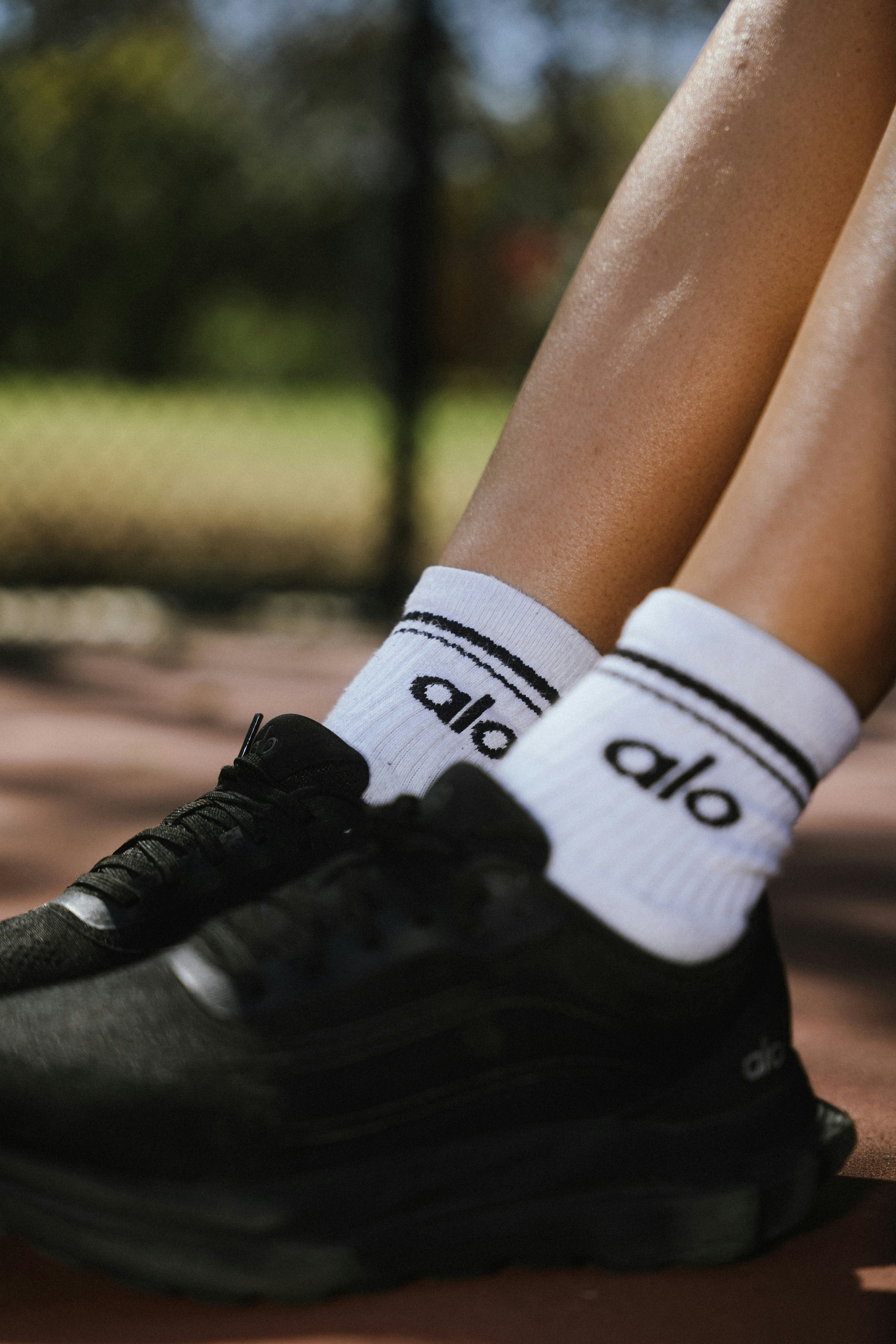 Soles in Focus: Sneakers and Socks on a Sunlit Court