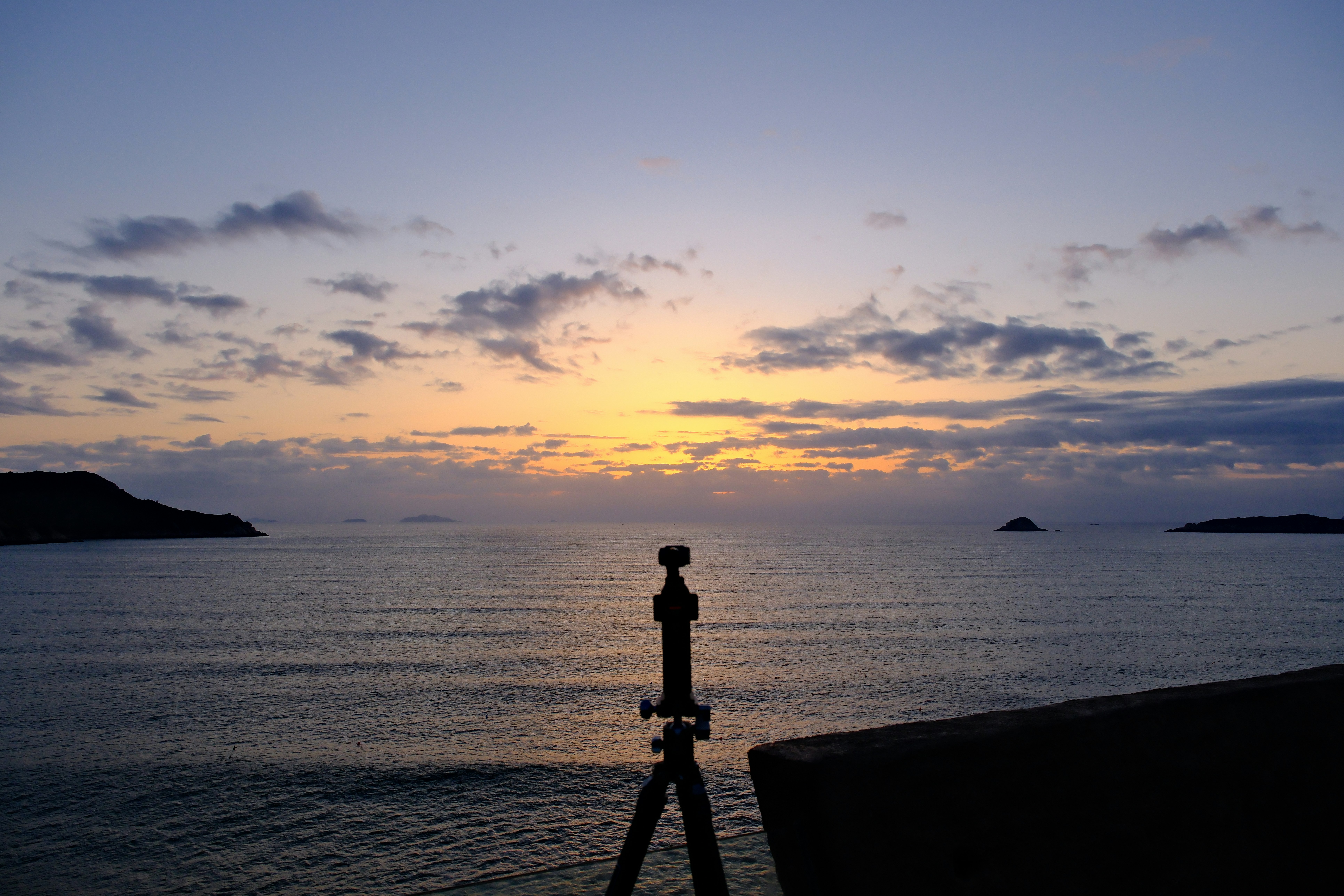 Sunset Silhouette: A Tripod Stands Guard at the Quiet Horizon