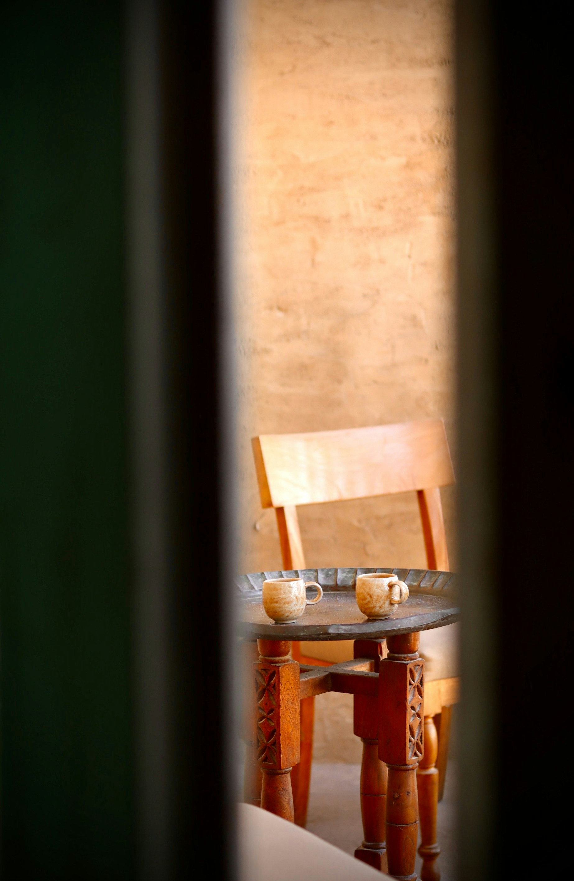 Partial glimpse: a quiet tea moment framed between slats