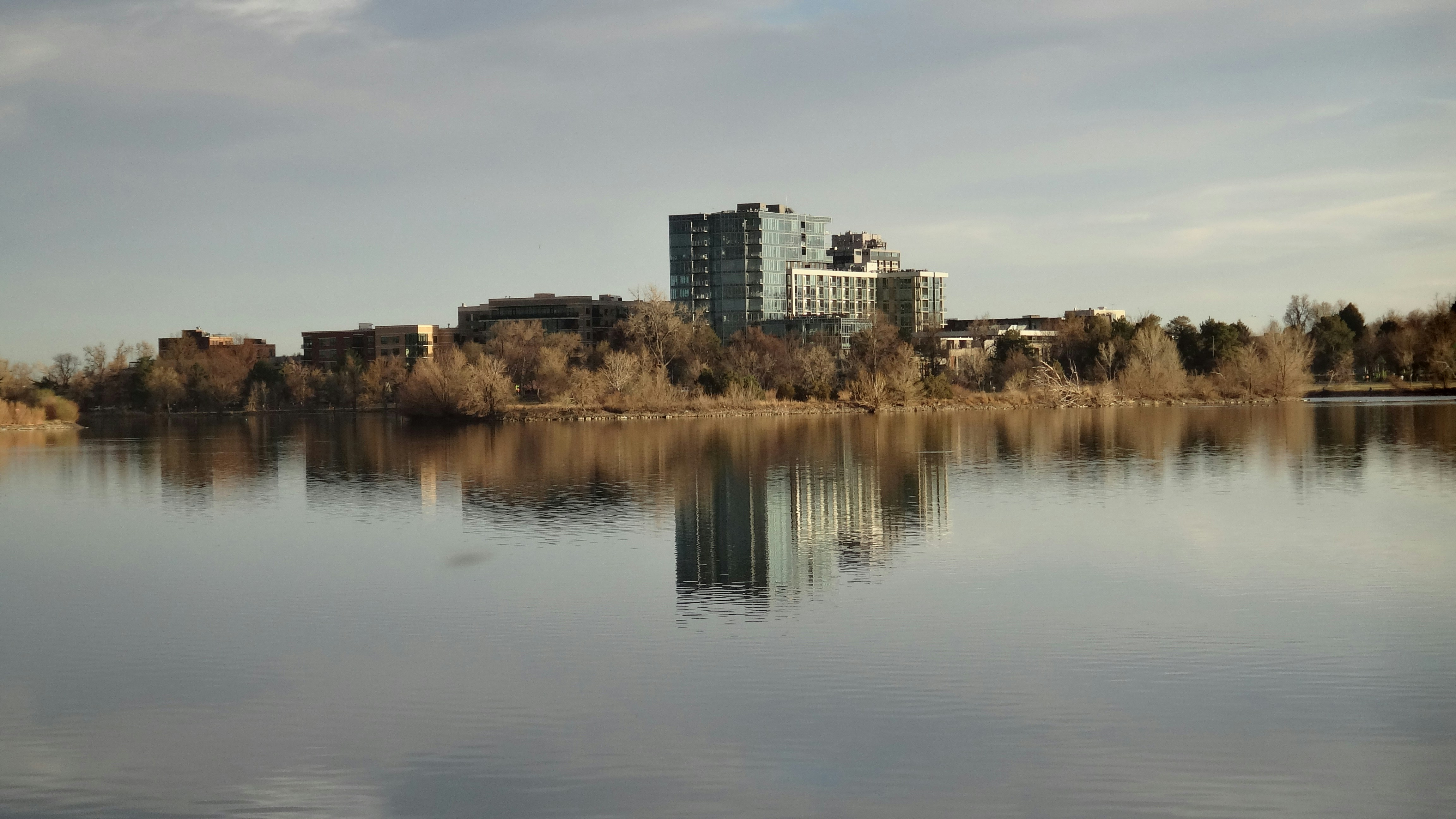 Glassy river, mirrored apartment block: calm morning cityscape