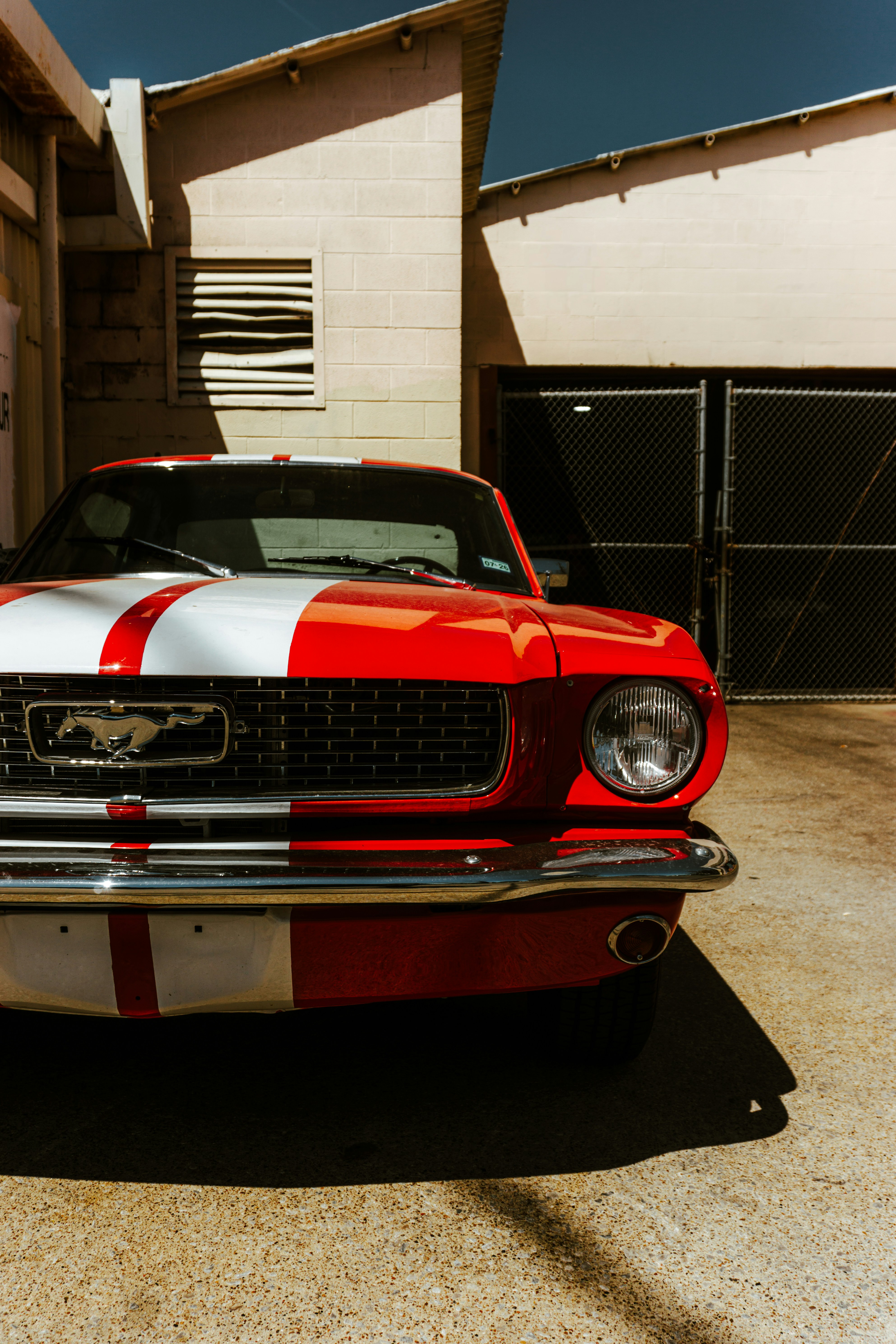 Red with Racing Stripes: A Classic Ford Framed by Industrial Backdrop