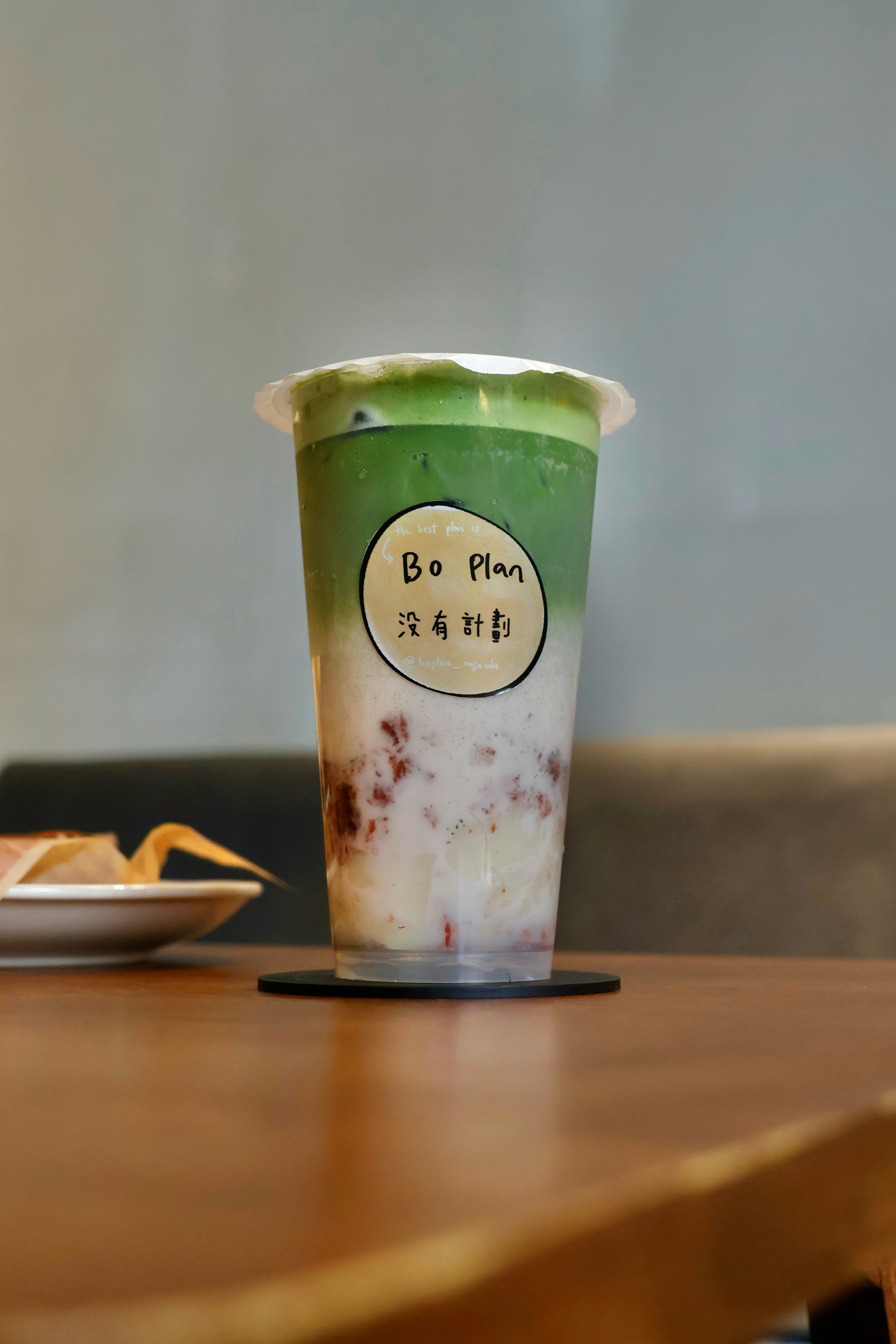 Green-misted Matcha in Focus: A Milk-Tea Portrait on a Wooden Table