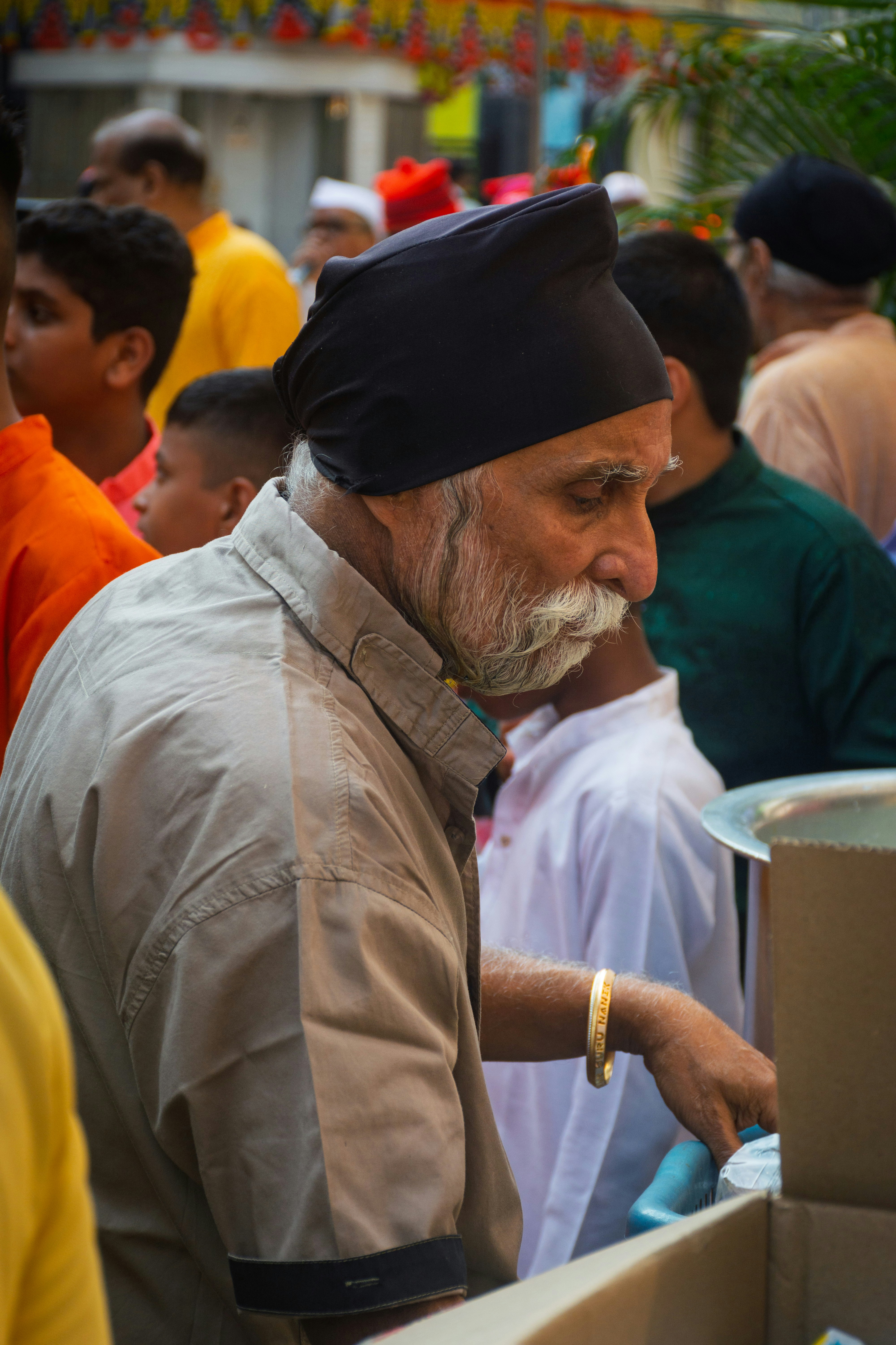 The Elder in Focus: A Contemplative Moment Amid the Crowd