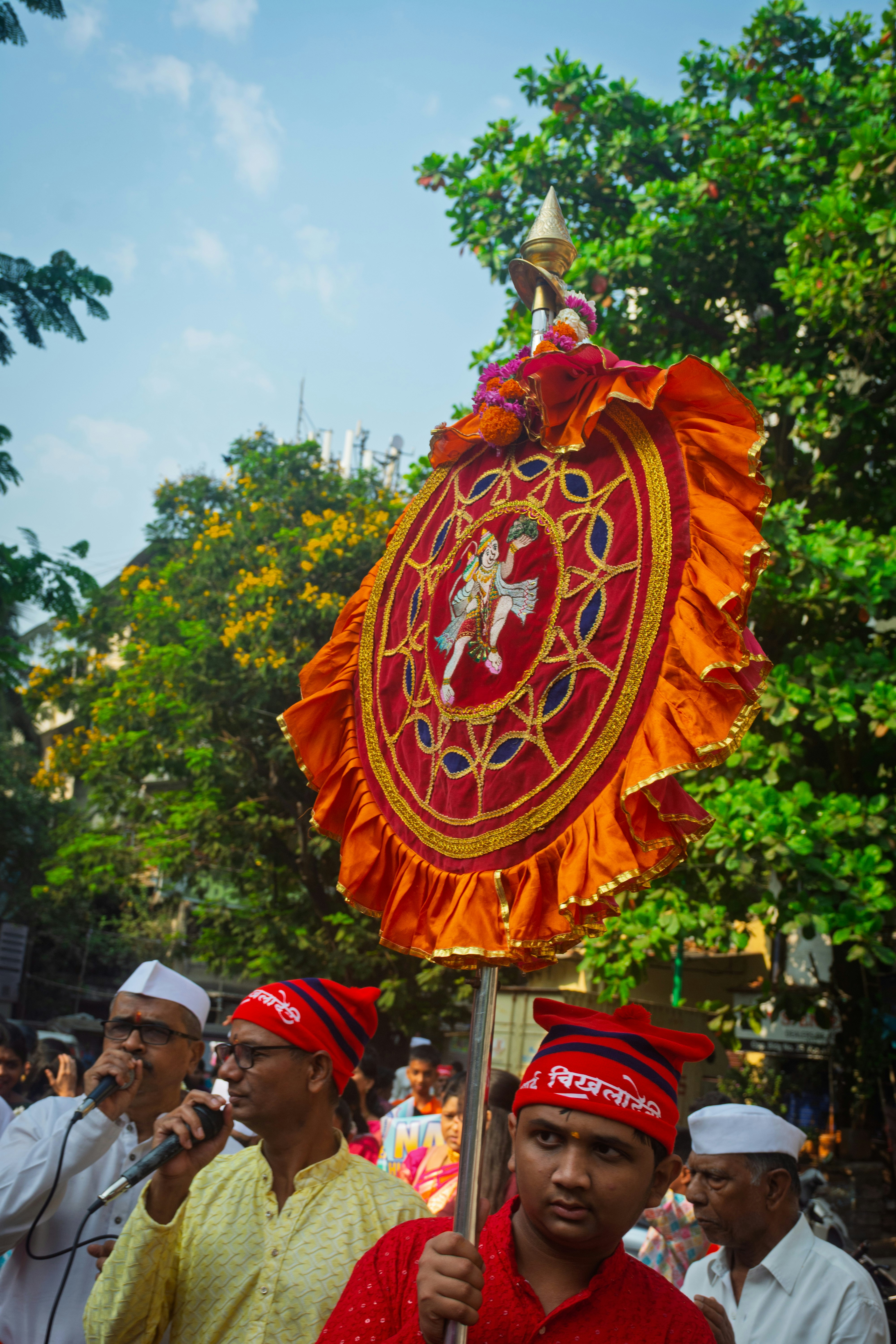 Vibrant ceremonial parasol over a crowd at a religious procession