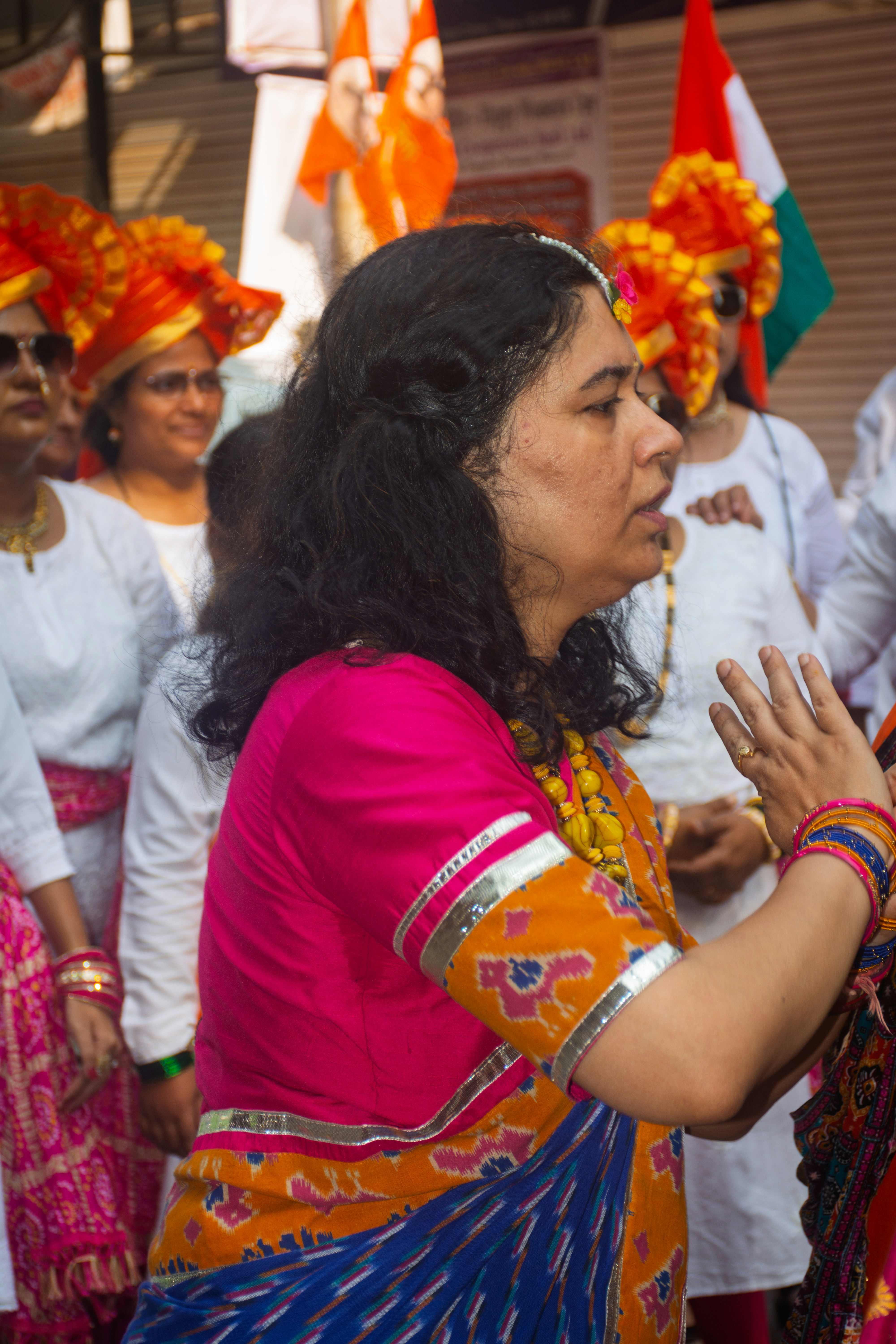 Vibrant procession: woman in magenta leading a festive moment