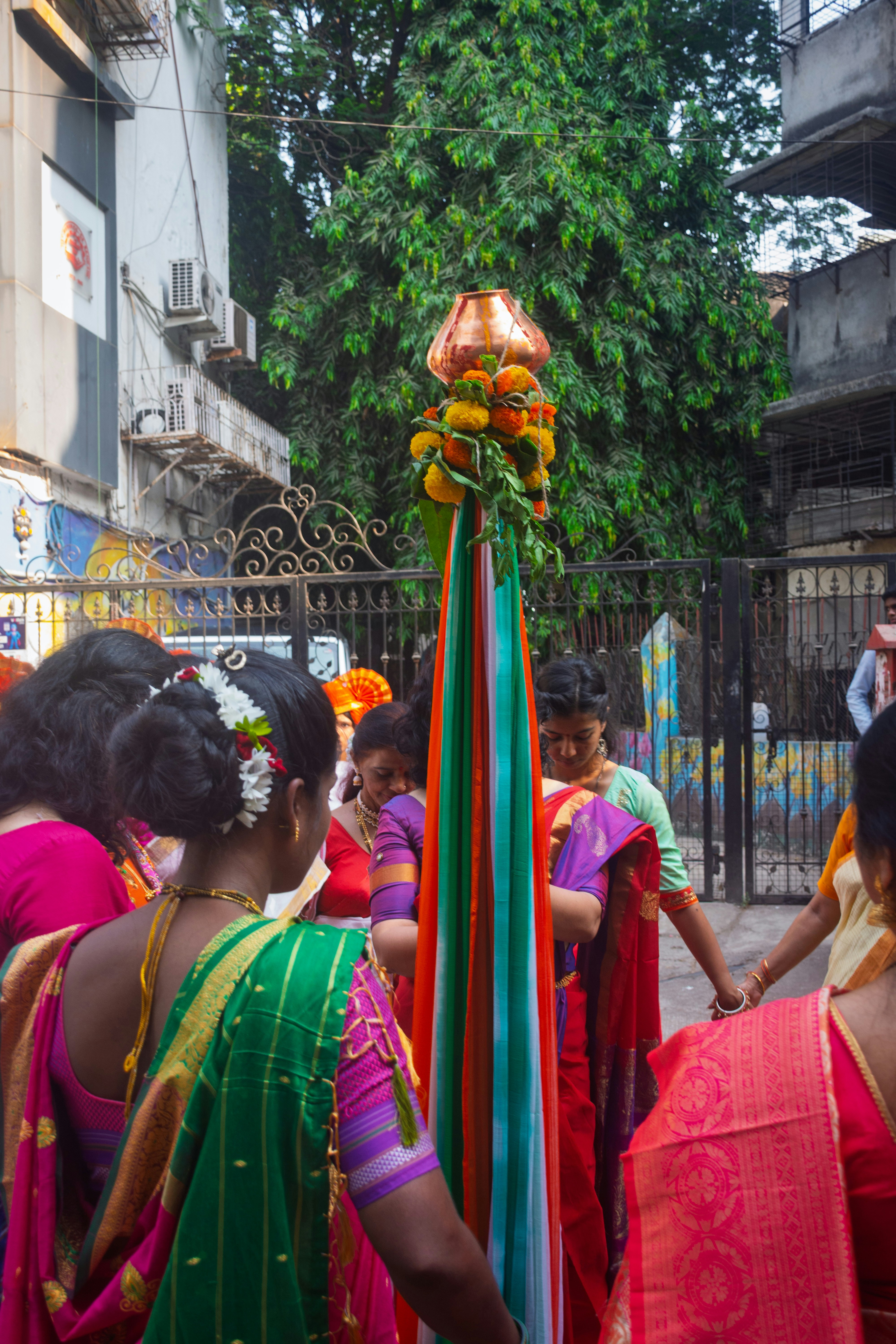 Colorful procession: a ceremonial pole carried among a crowd of women