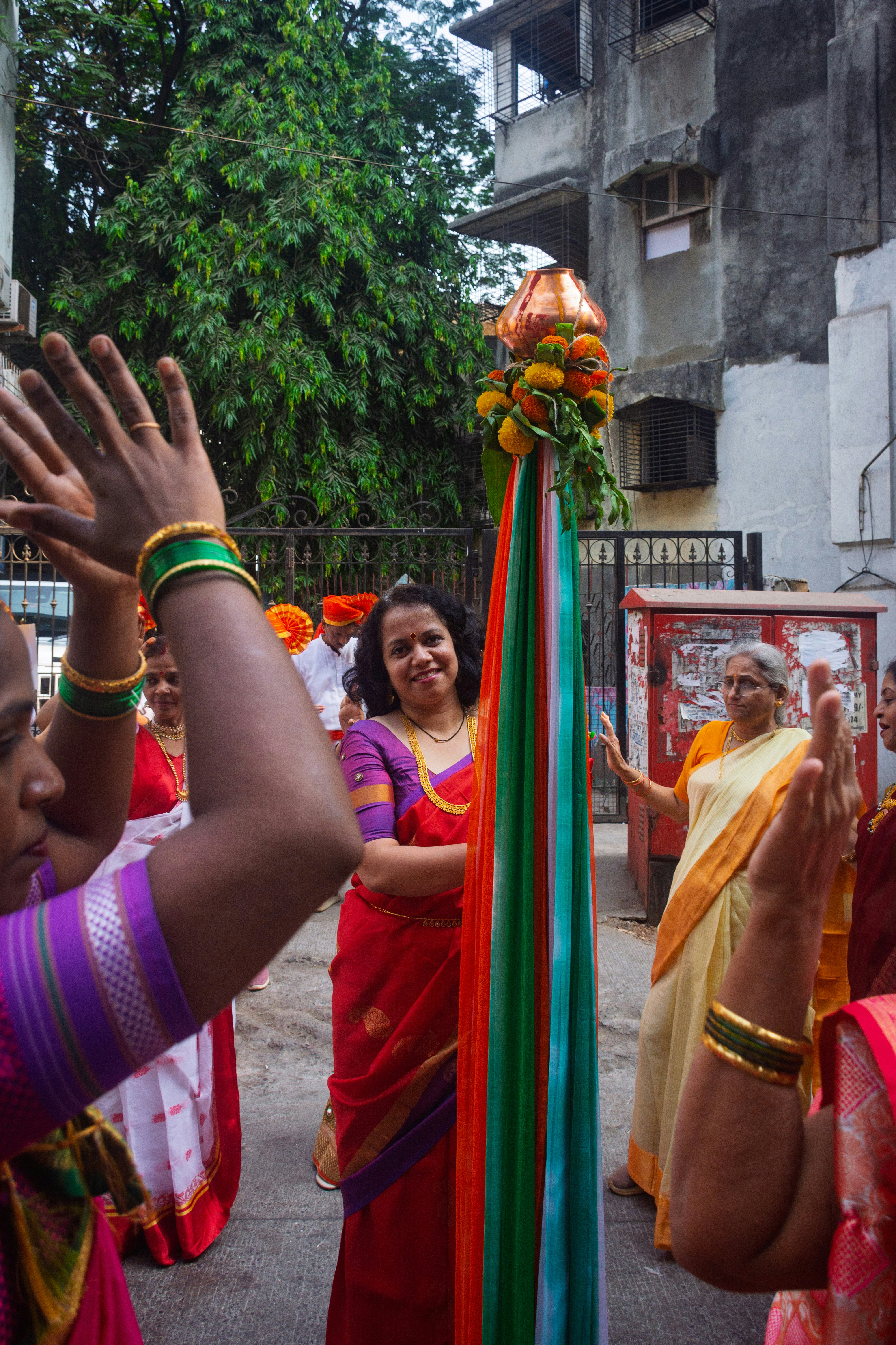 Colorful Street Ritual: A Woman Guards a Floral Mantle During a Procession
