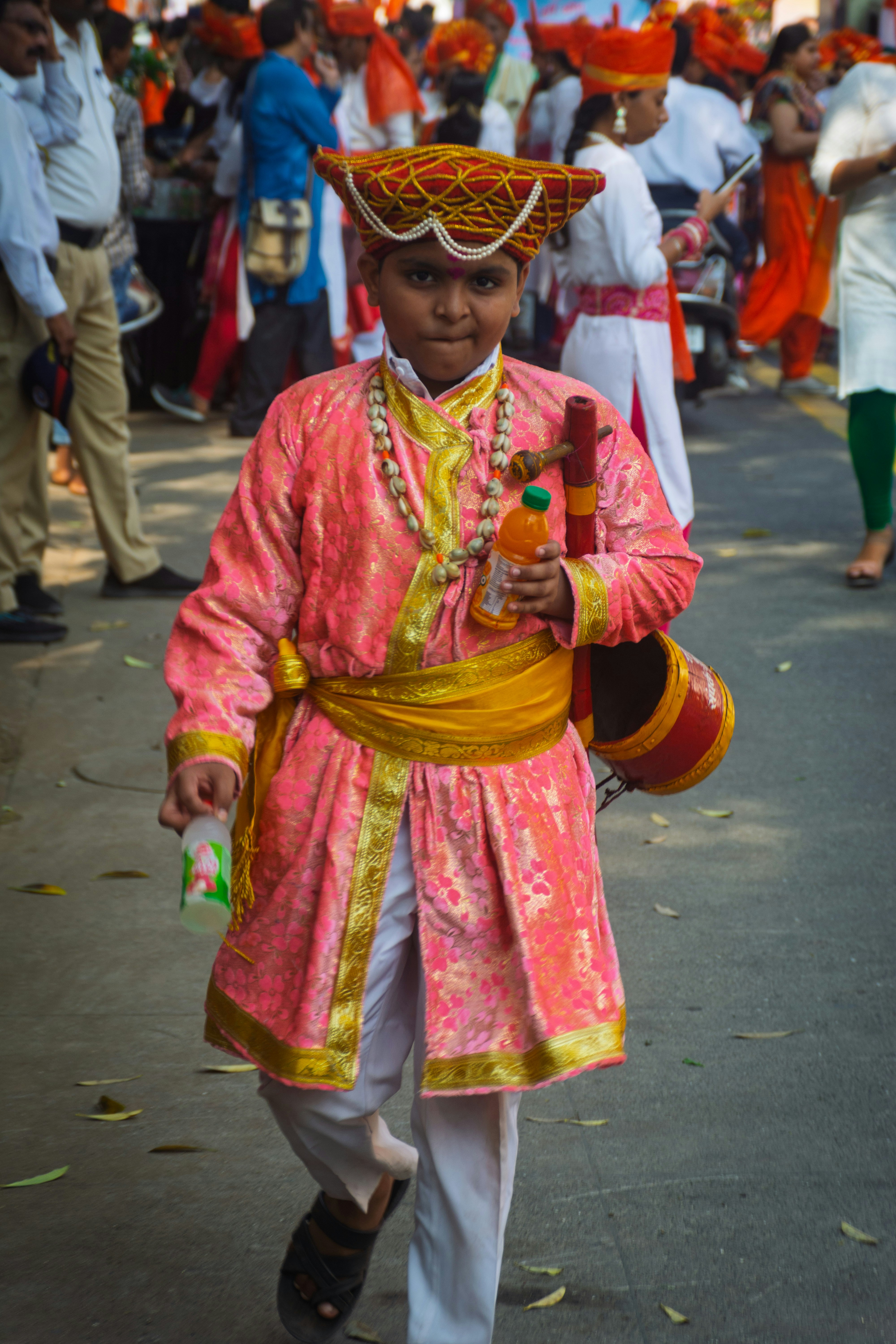 Pink ceremonial sherwani: a young performer in festive parade