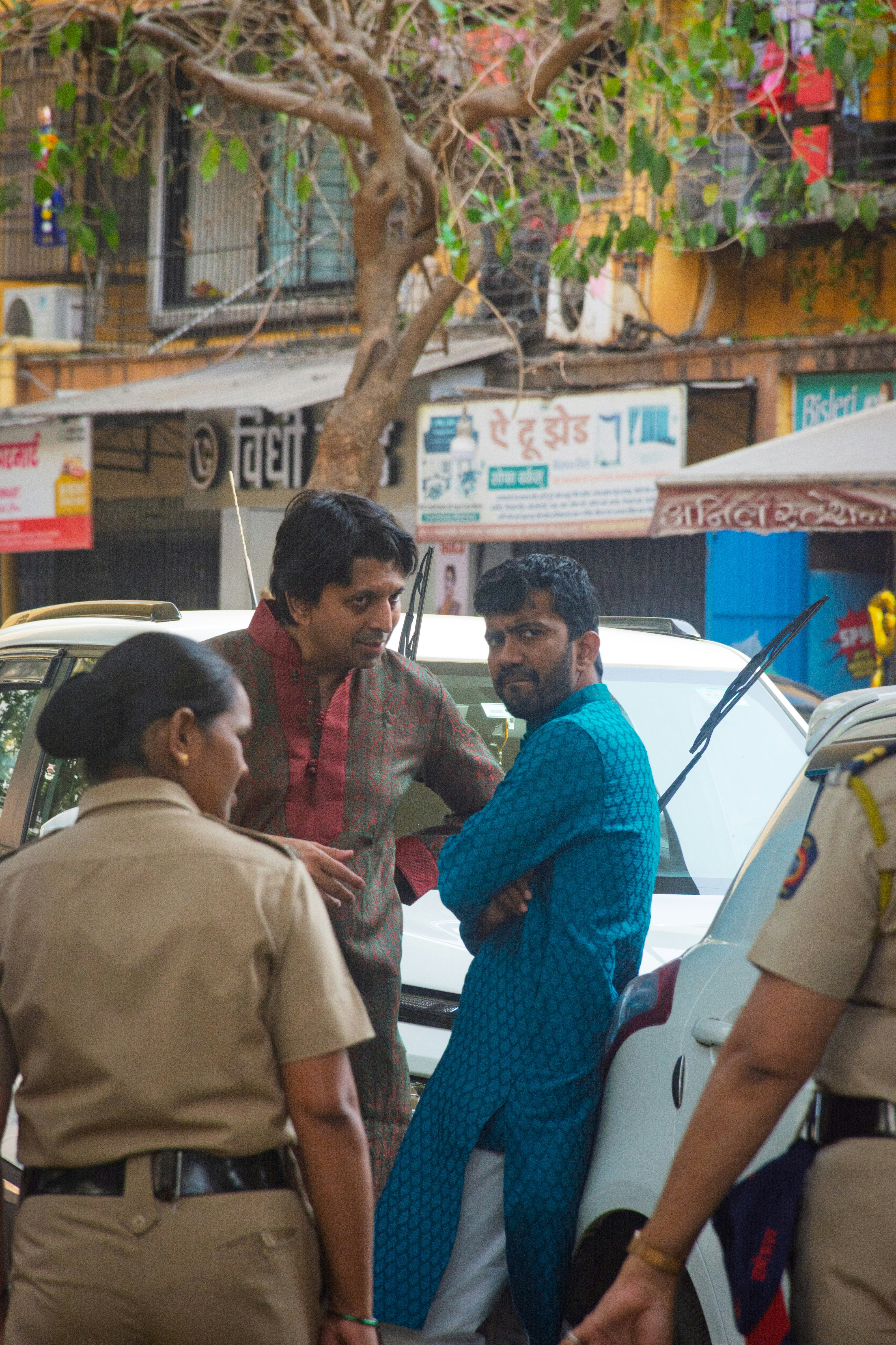 Conversations in the Street: Two Men in Colorful Attire Amid City Activity