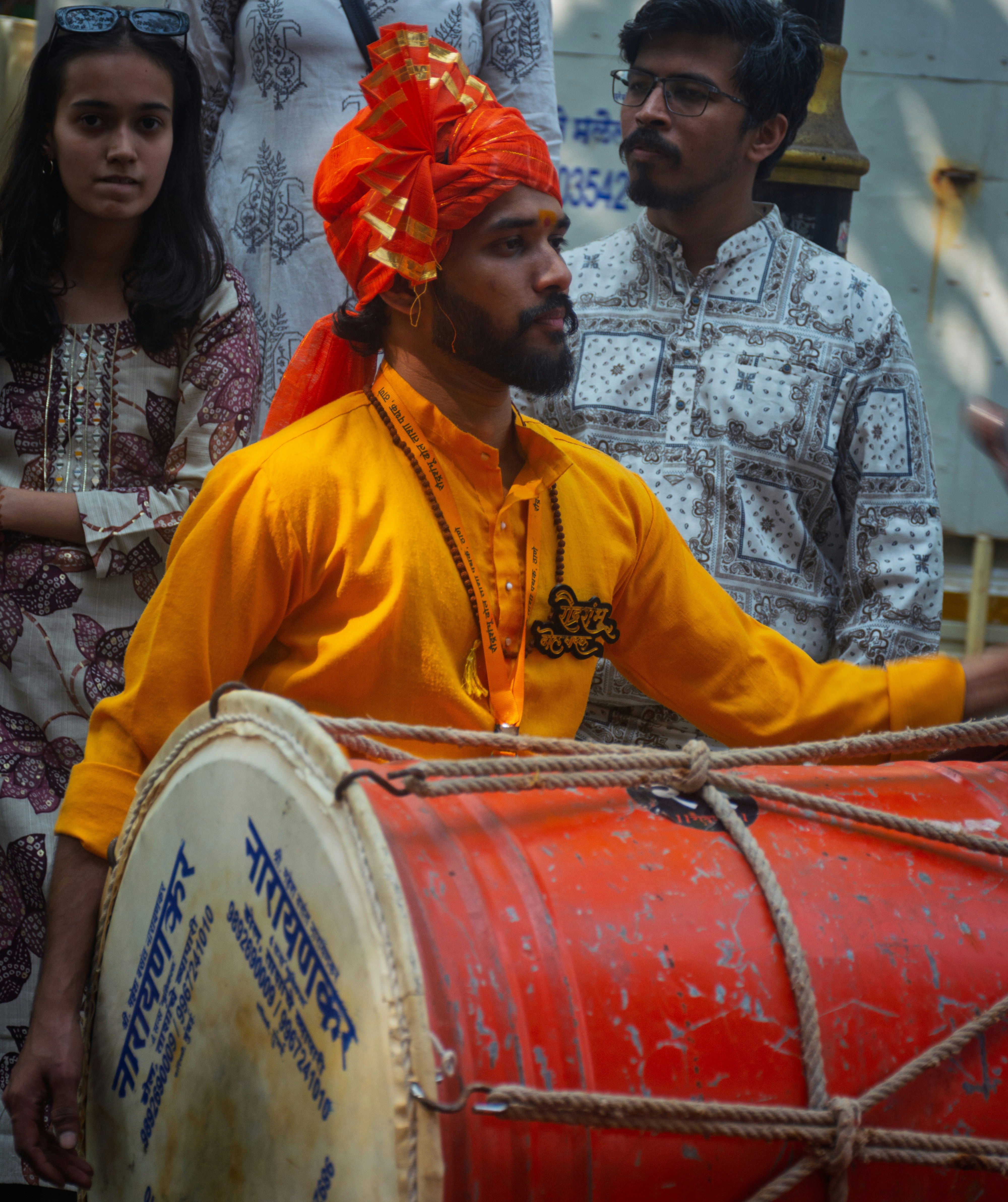 Rhythms of Color: Drummer in Bright Orange at a Festival Moment