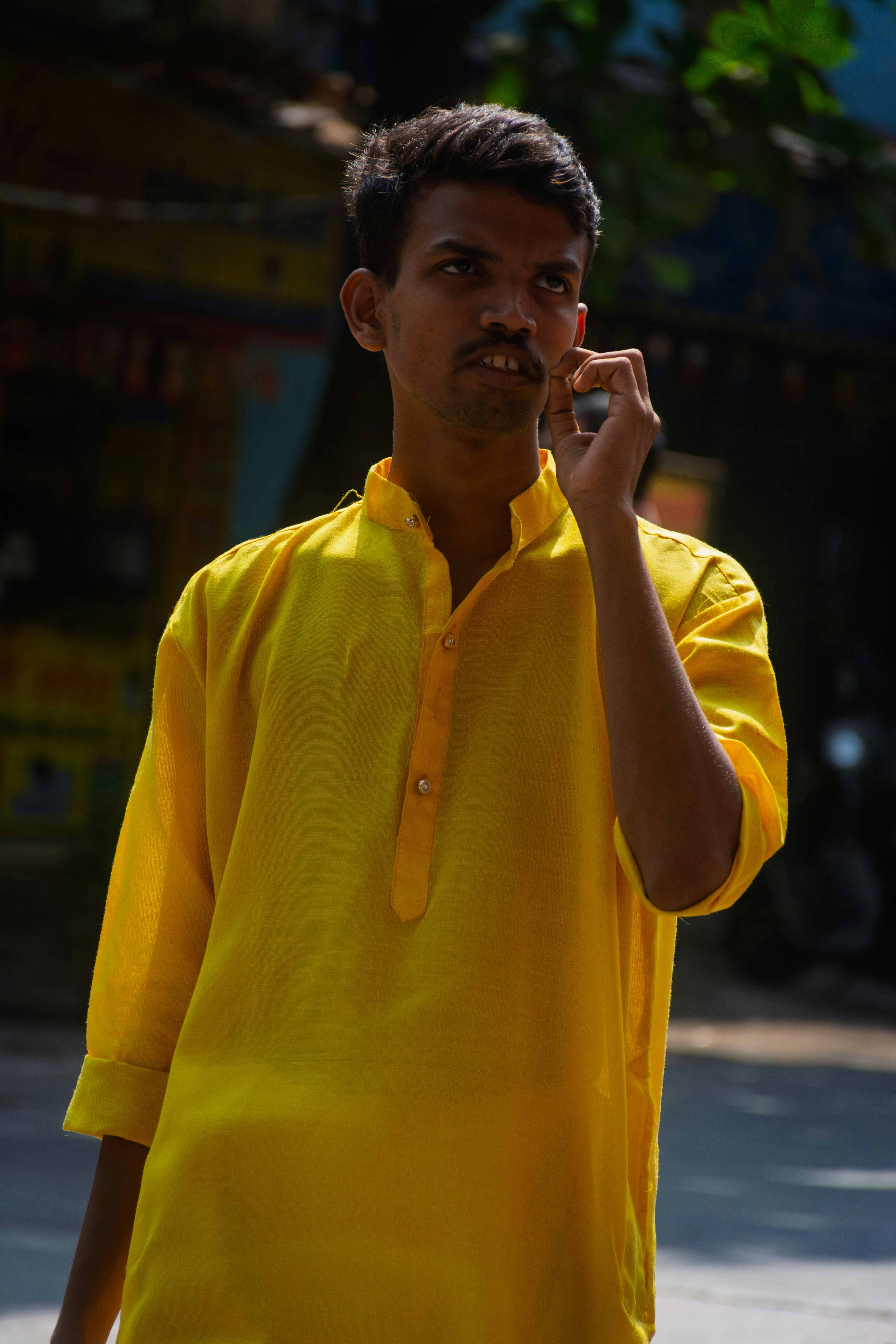 Sunlit Yellow Kurta: A Pensive Moment Under Dappled Shade