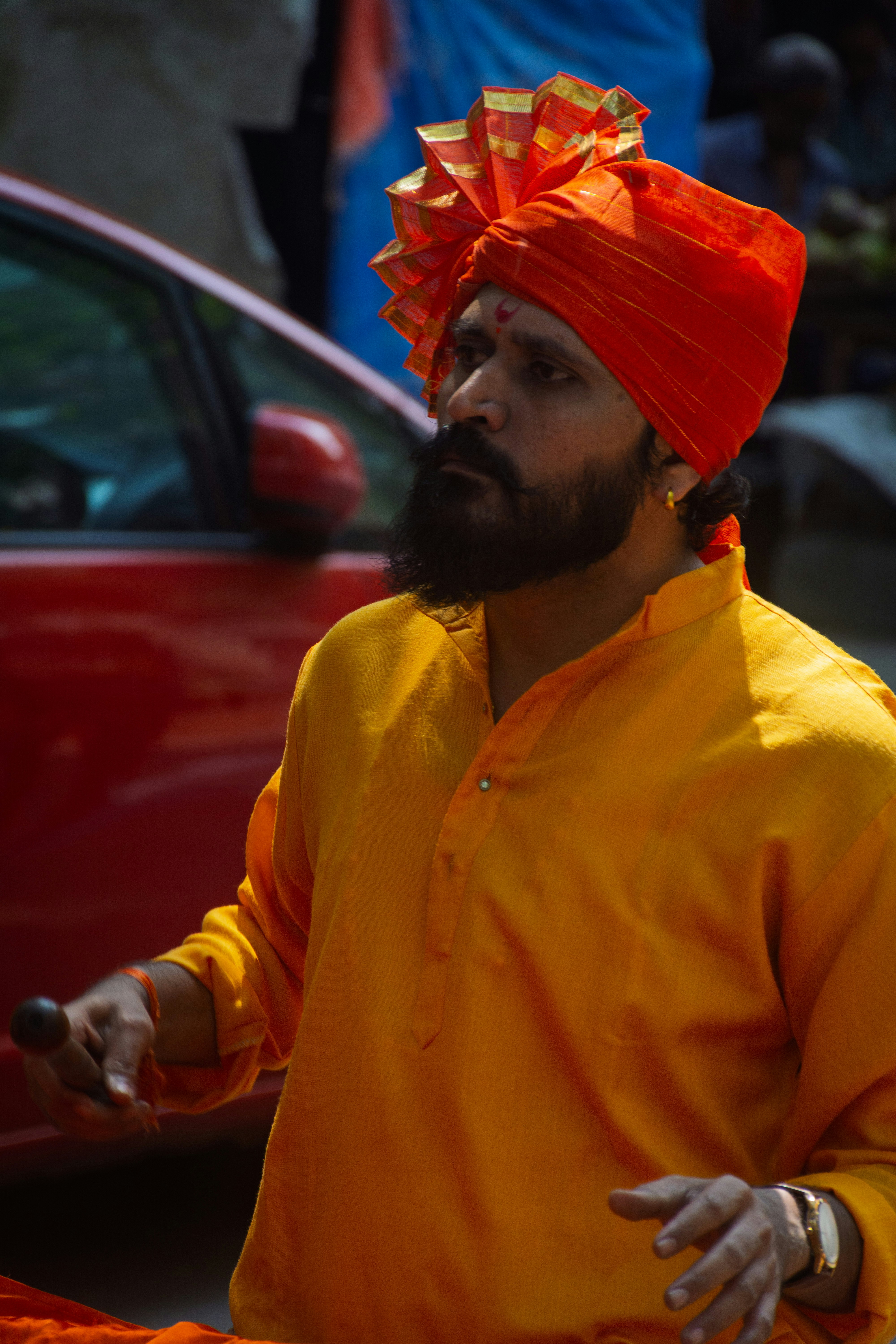 Vibrant Gurjar in Orange Turban: Portrait of Color and Craft