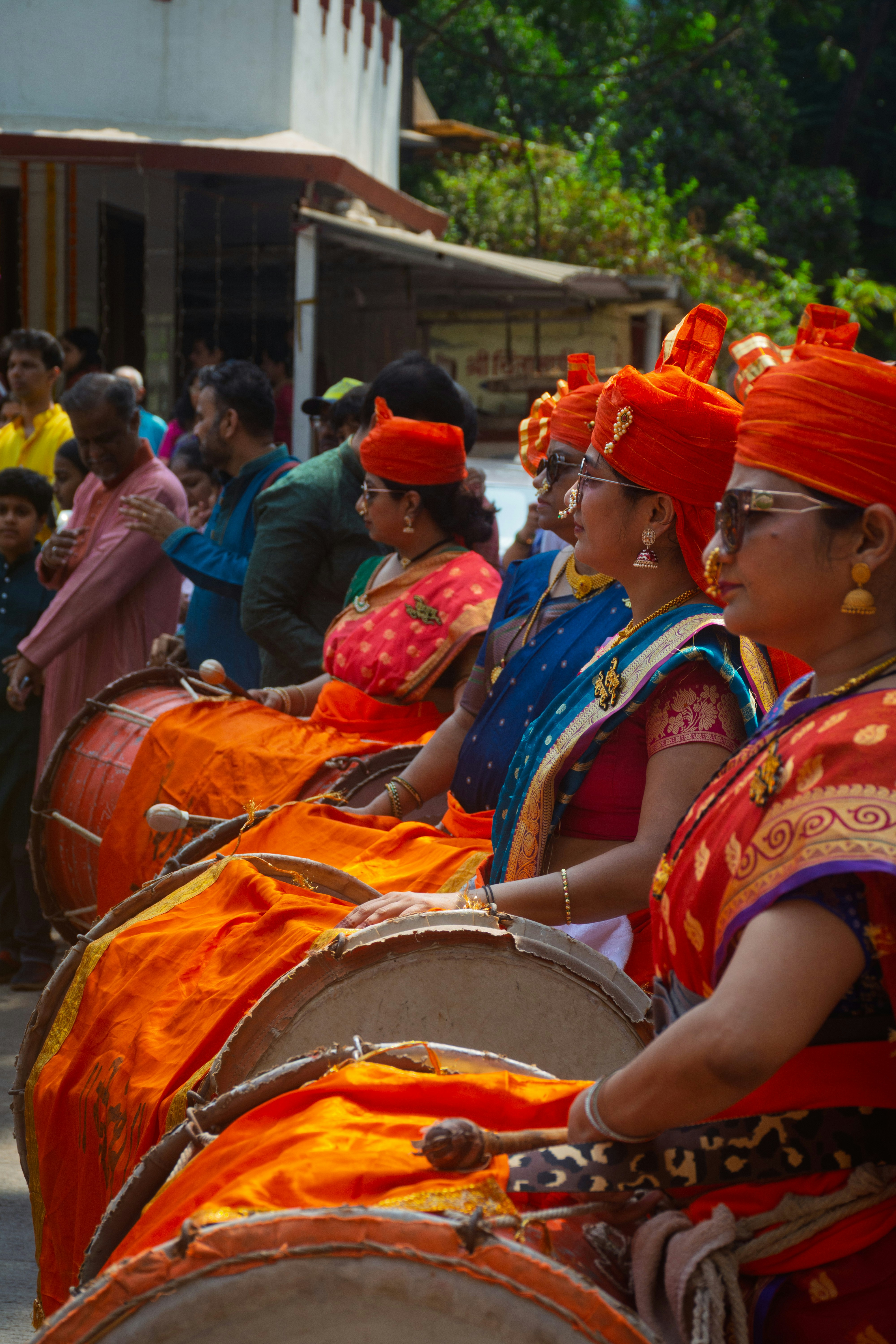 Vibrant Drummers in Orange Attire Lead a Street Procession