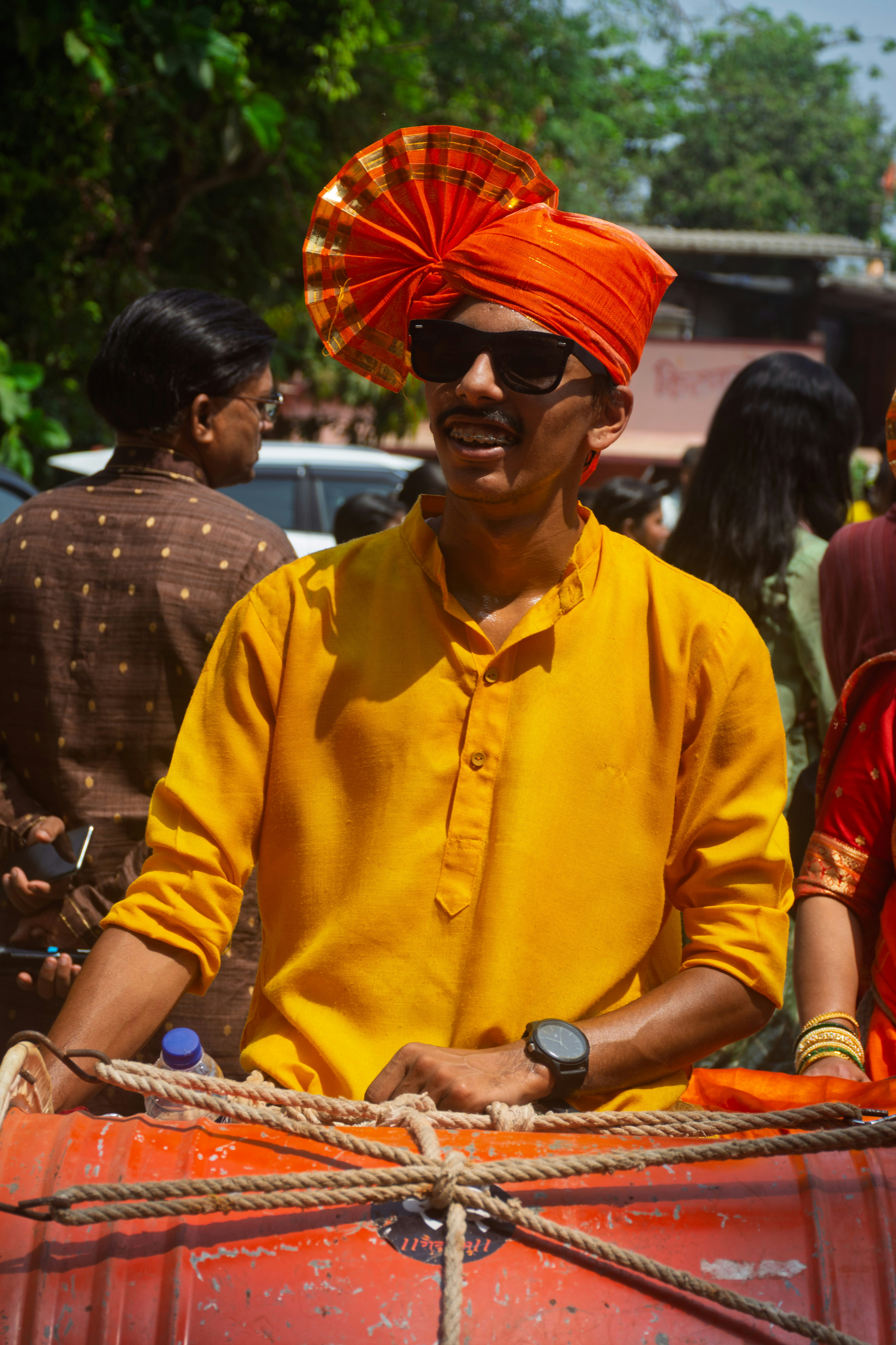 Vibrant Festival Portrait: The Orange Turban Amid a Crowd