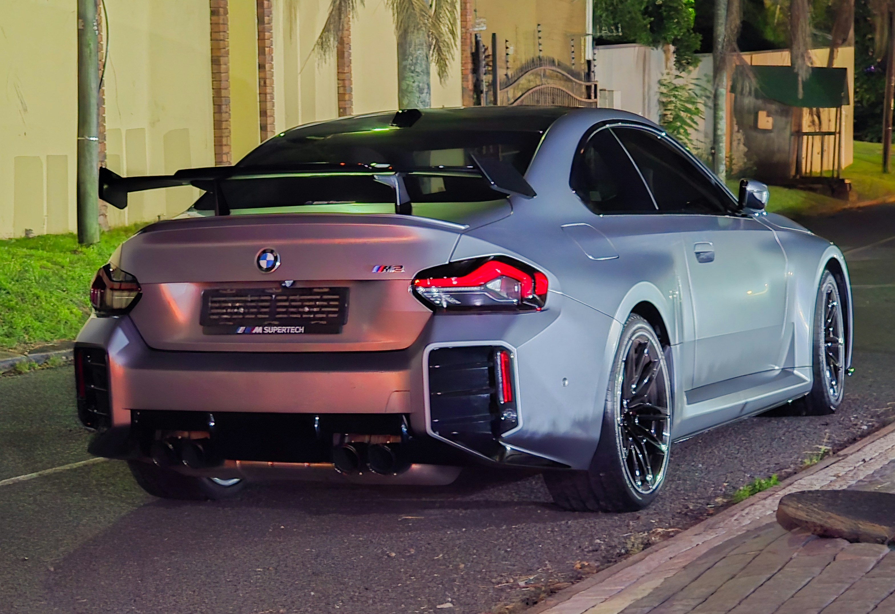 Midnight Silver M8: A rear-quarter portrait of a tuned BMW M2 on urban dusk