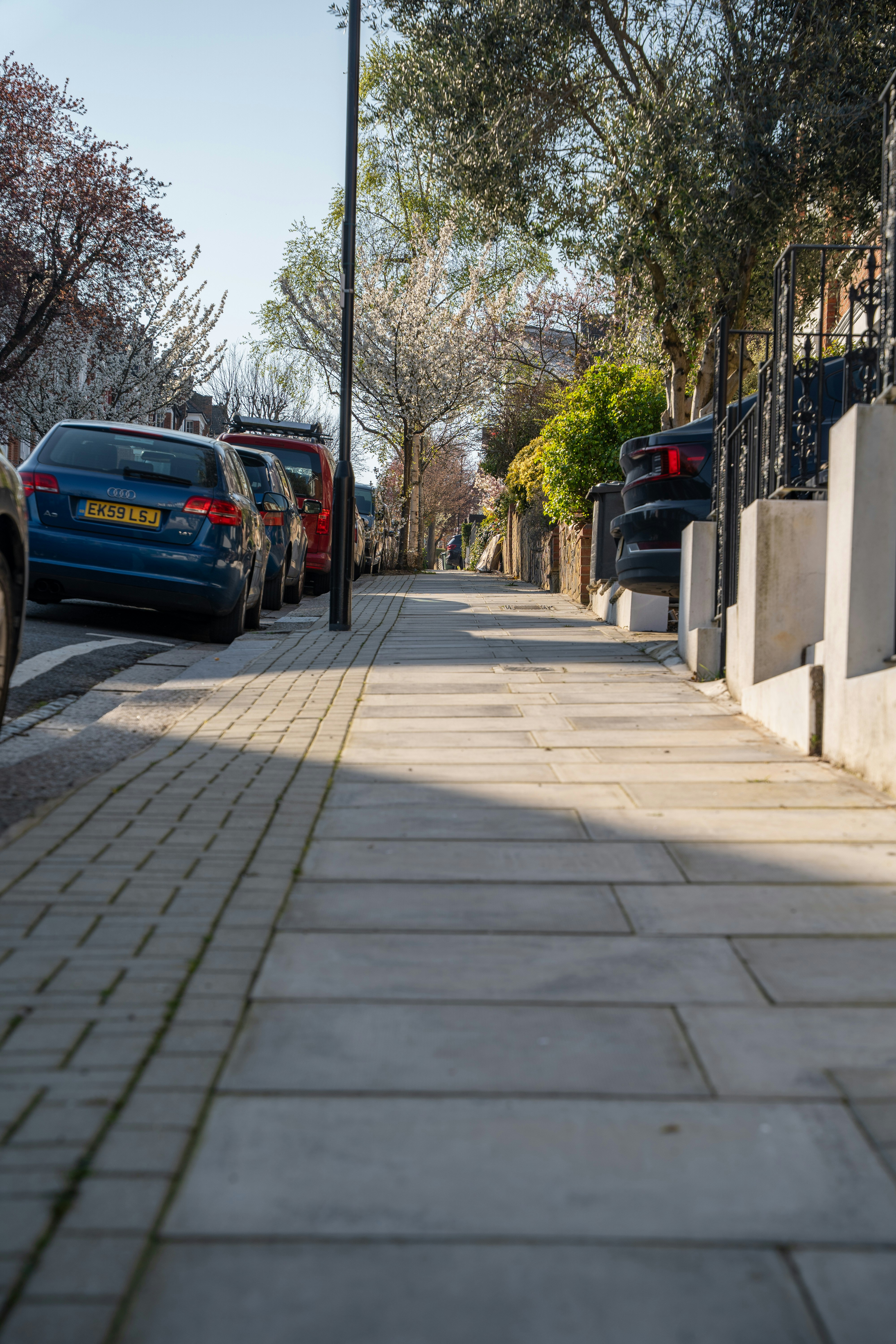 A Quiet Urban Pedestrian Path Framed by Cars and Trees