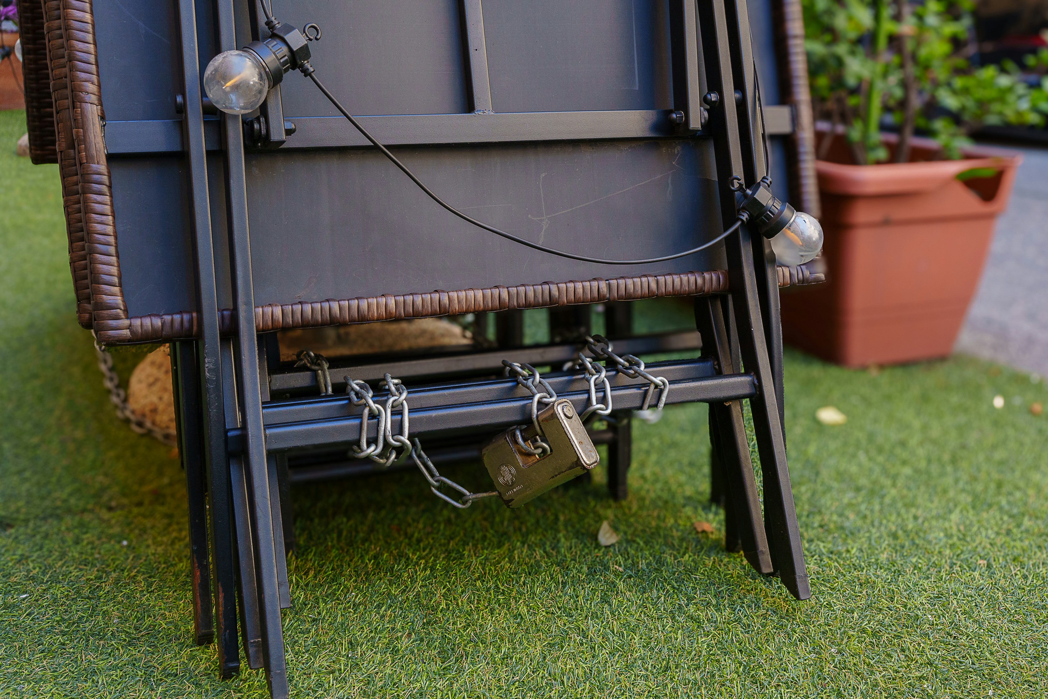 Locked in Place: a chained latch under a wooden cart in sunny garden turf