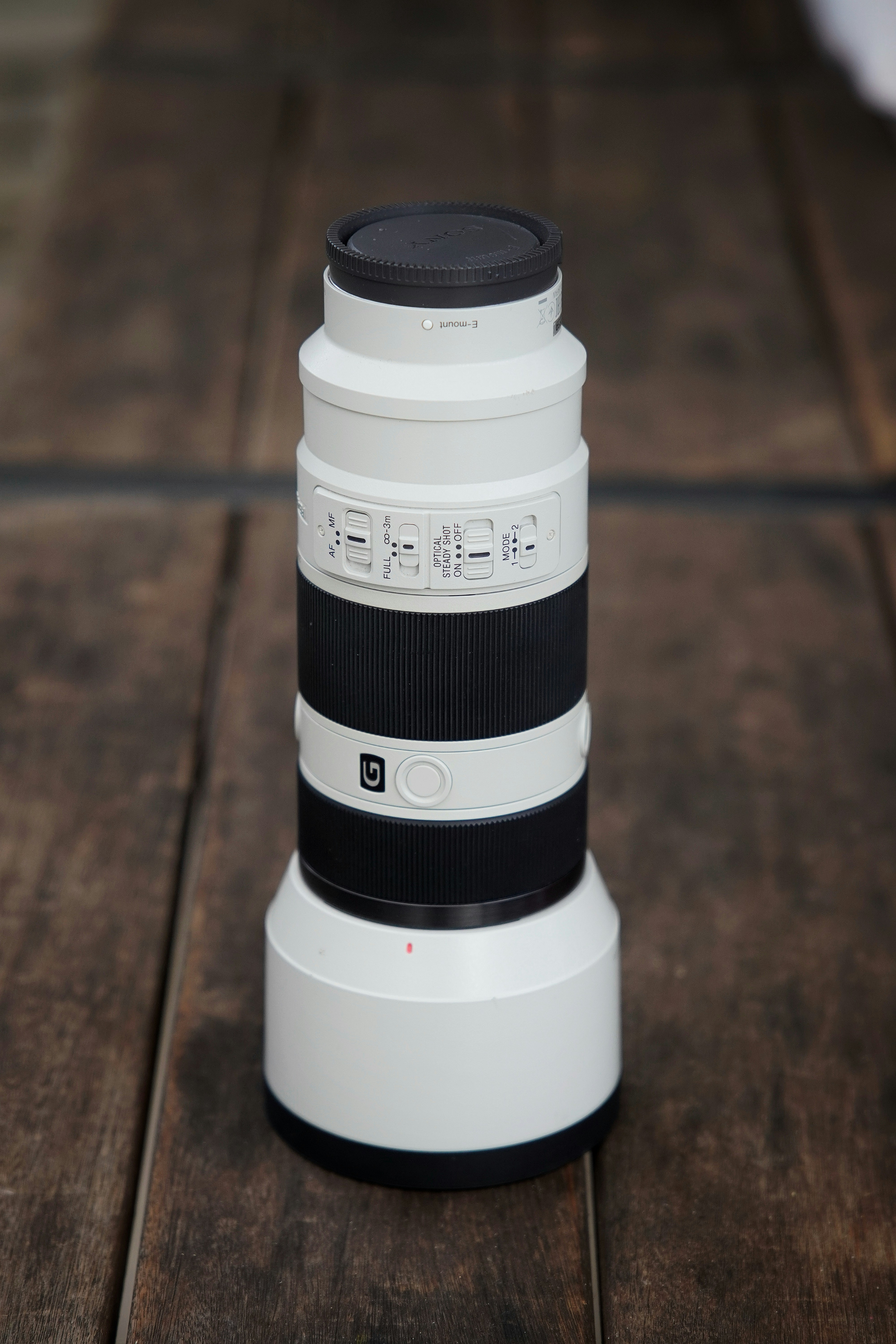White Telephoto Tower: A Close-Up Portrait of a Lens on Weathered Wood
