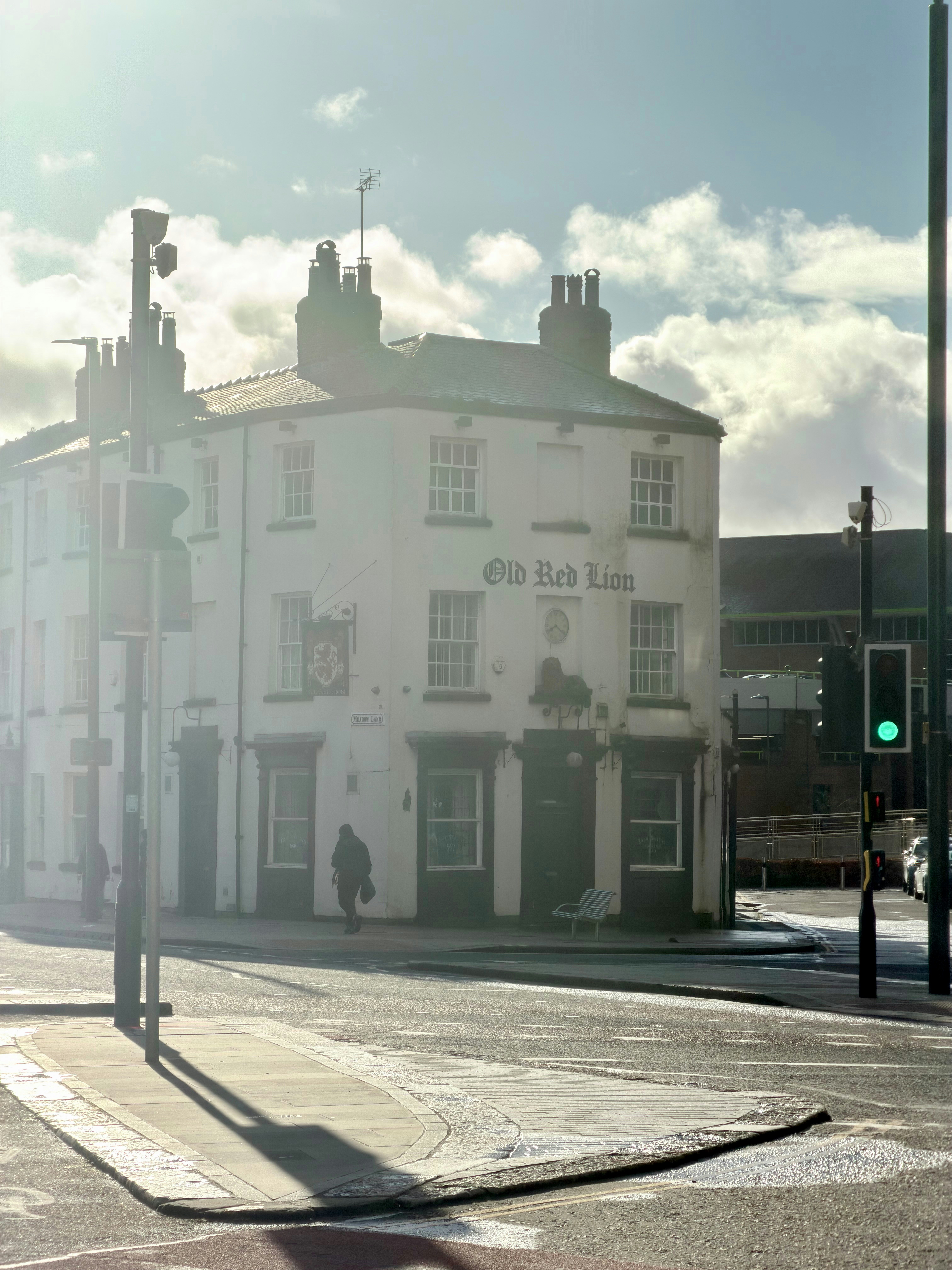 Old Red Lion at the Corner: Sunlit White Facade and Street Scene