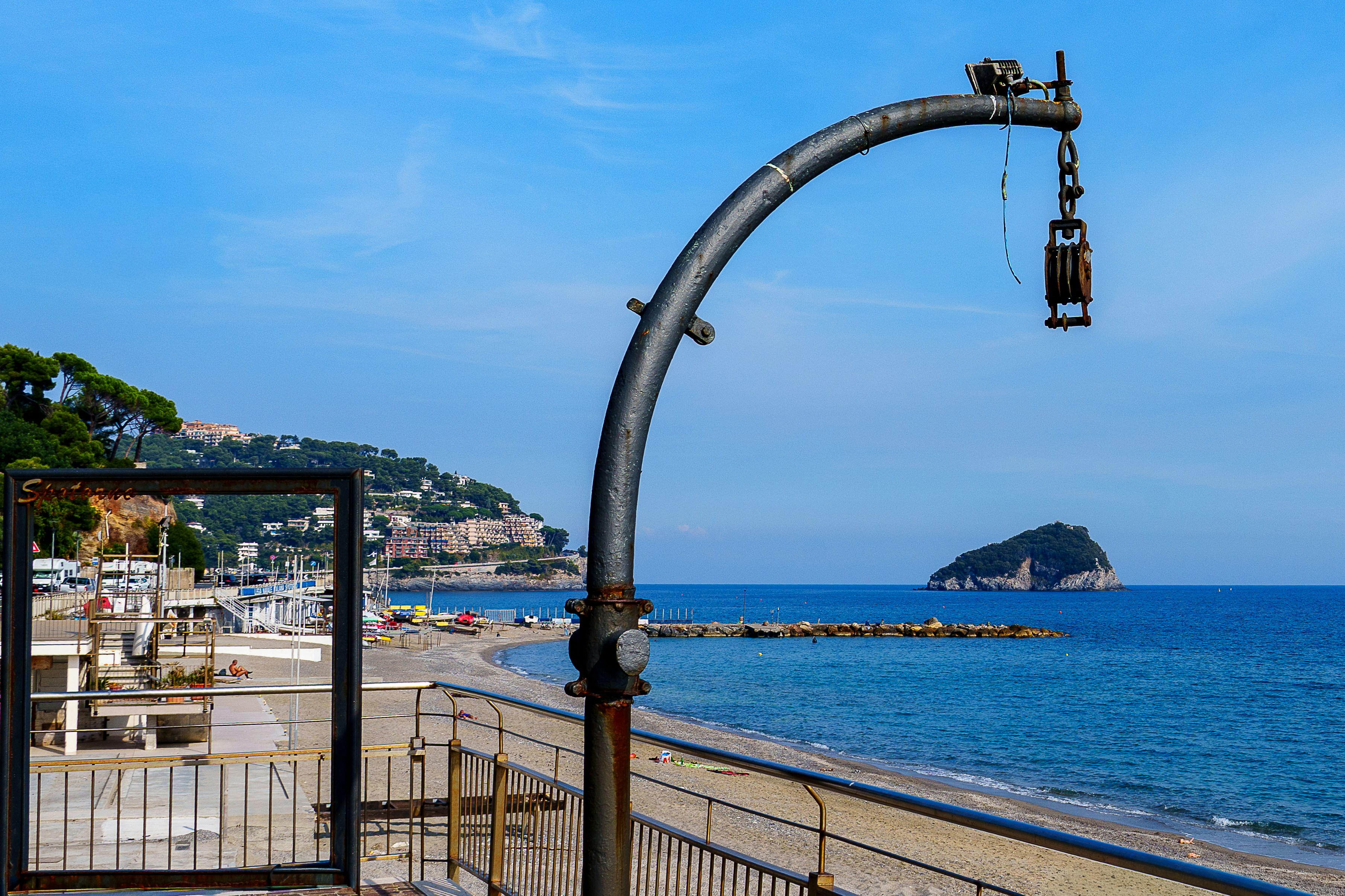 Harbor Arc: A Curved Crane Silhouette Against a Coastal Promenade