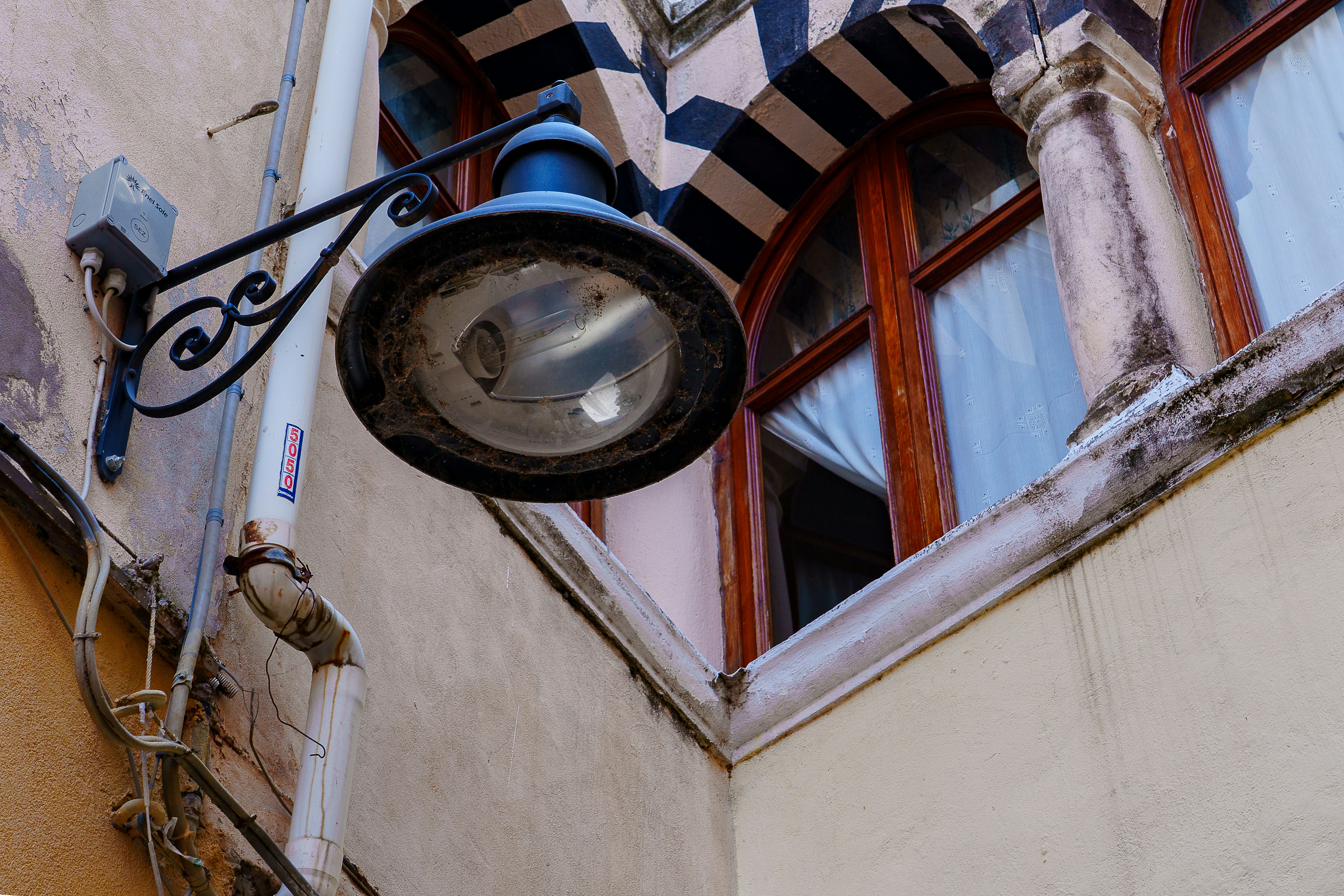 Vintage Street Lantern Overlooking a Coral-Tinted Archway