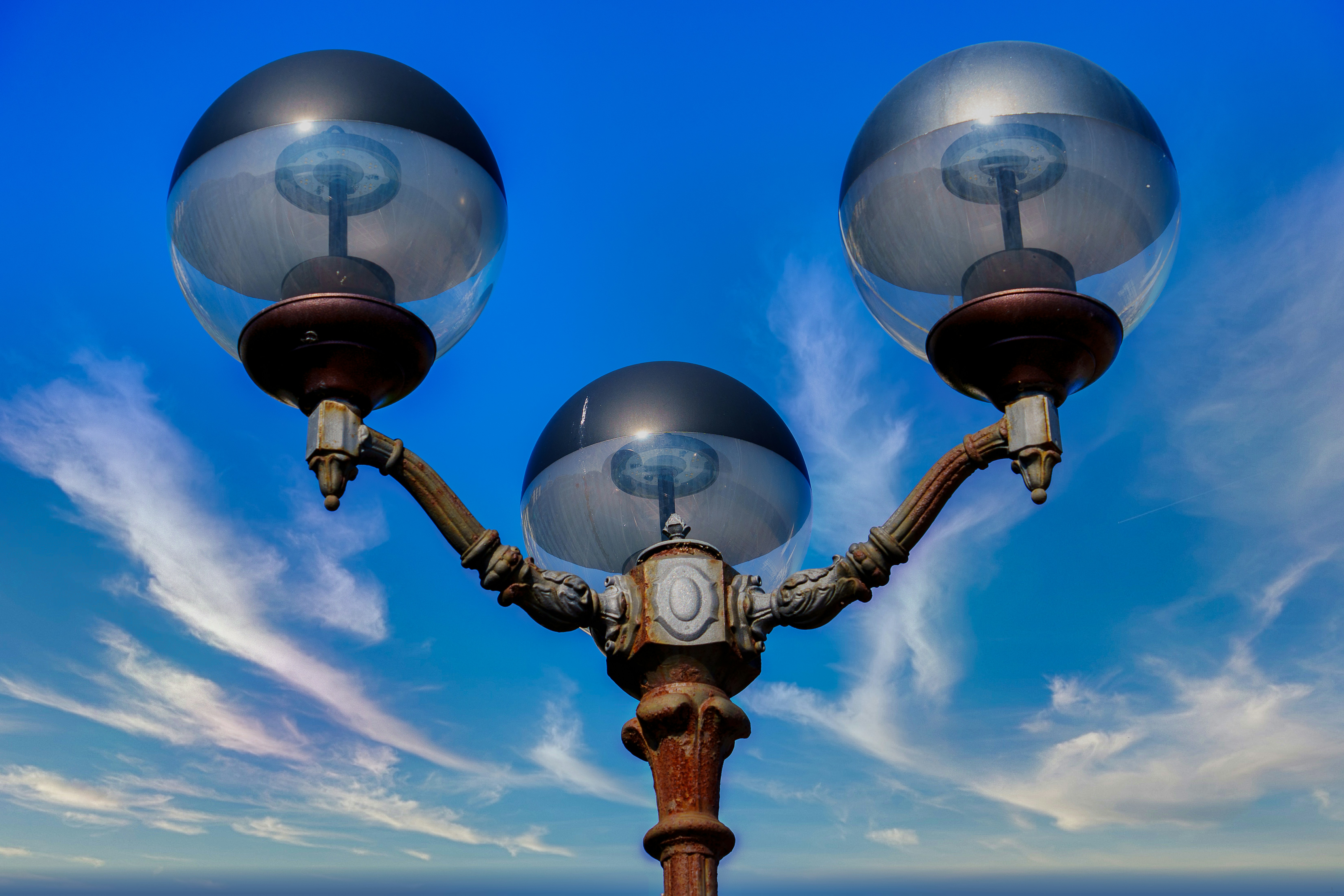 Three-Globe Street Lamp Reaching Toward a Clear Sky
