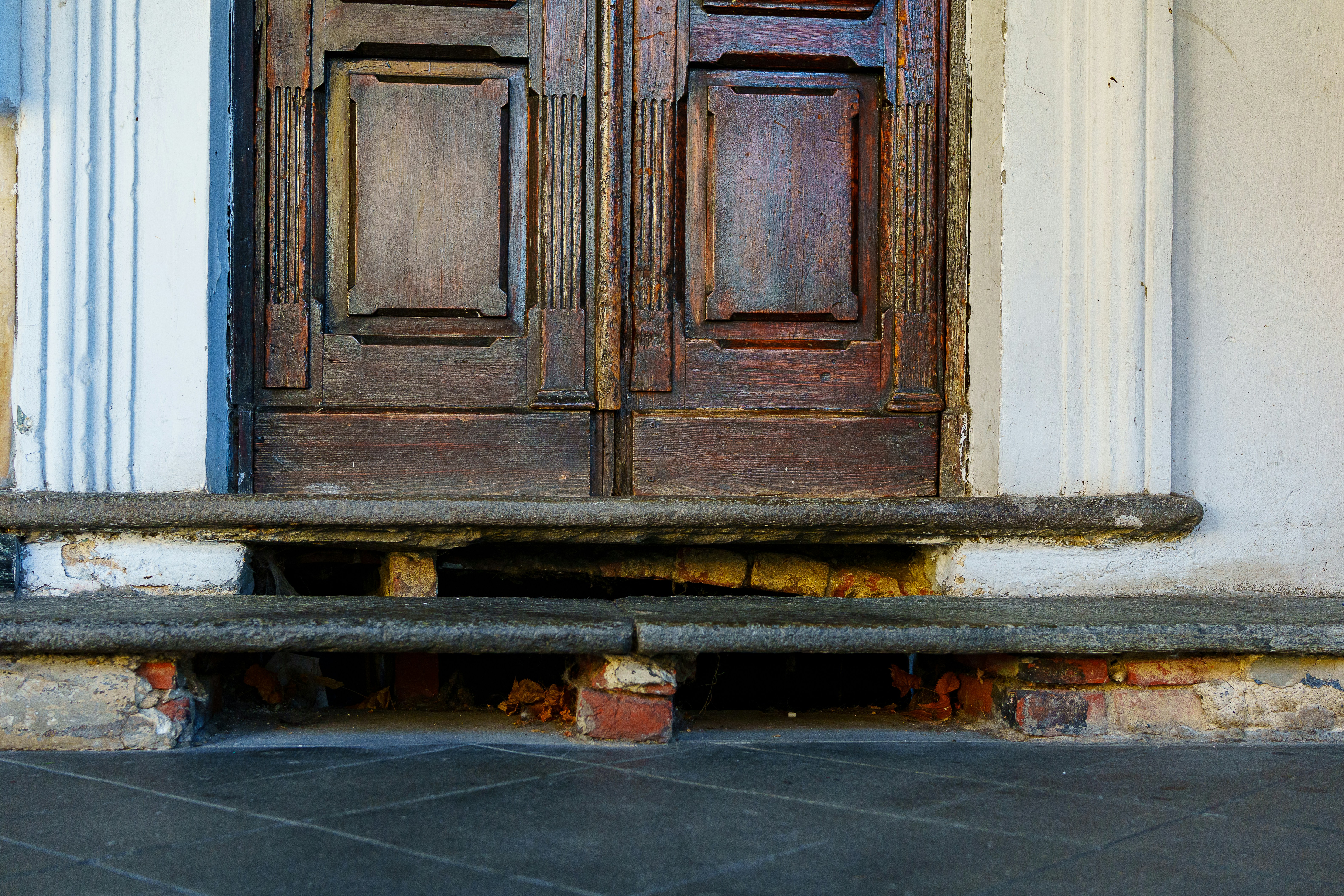 Weathered doorway and step reveal hidden brick supports