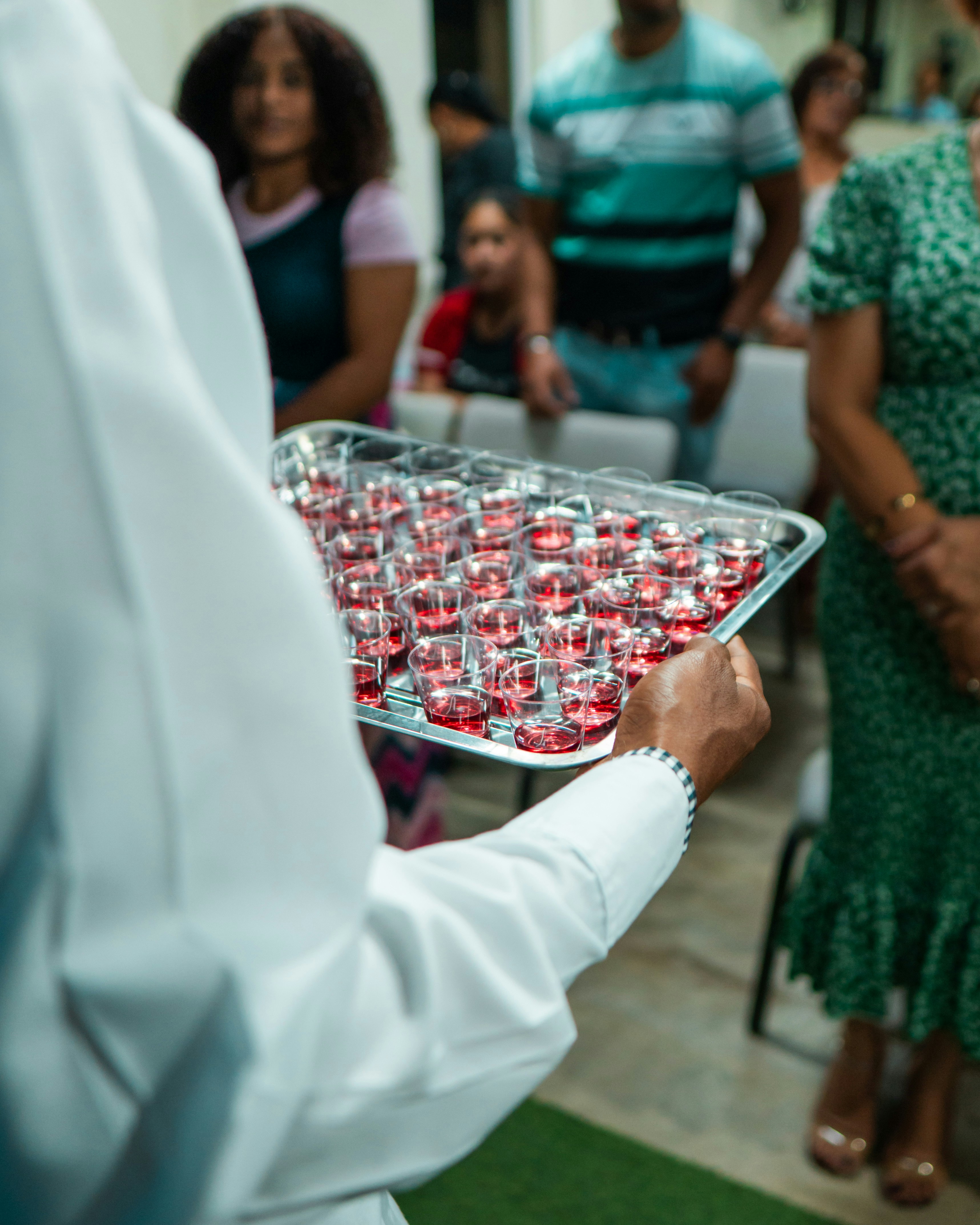 Tray of red beverages: a ceremonial serve in a social gathering
