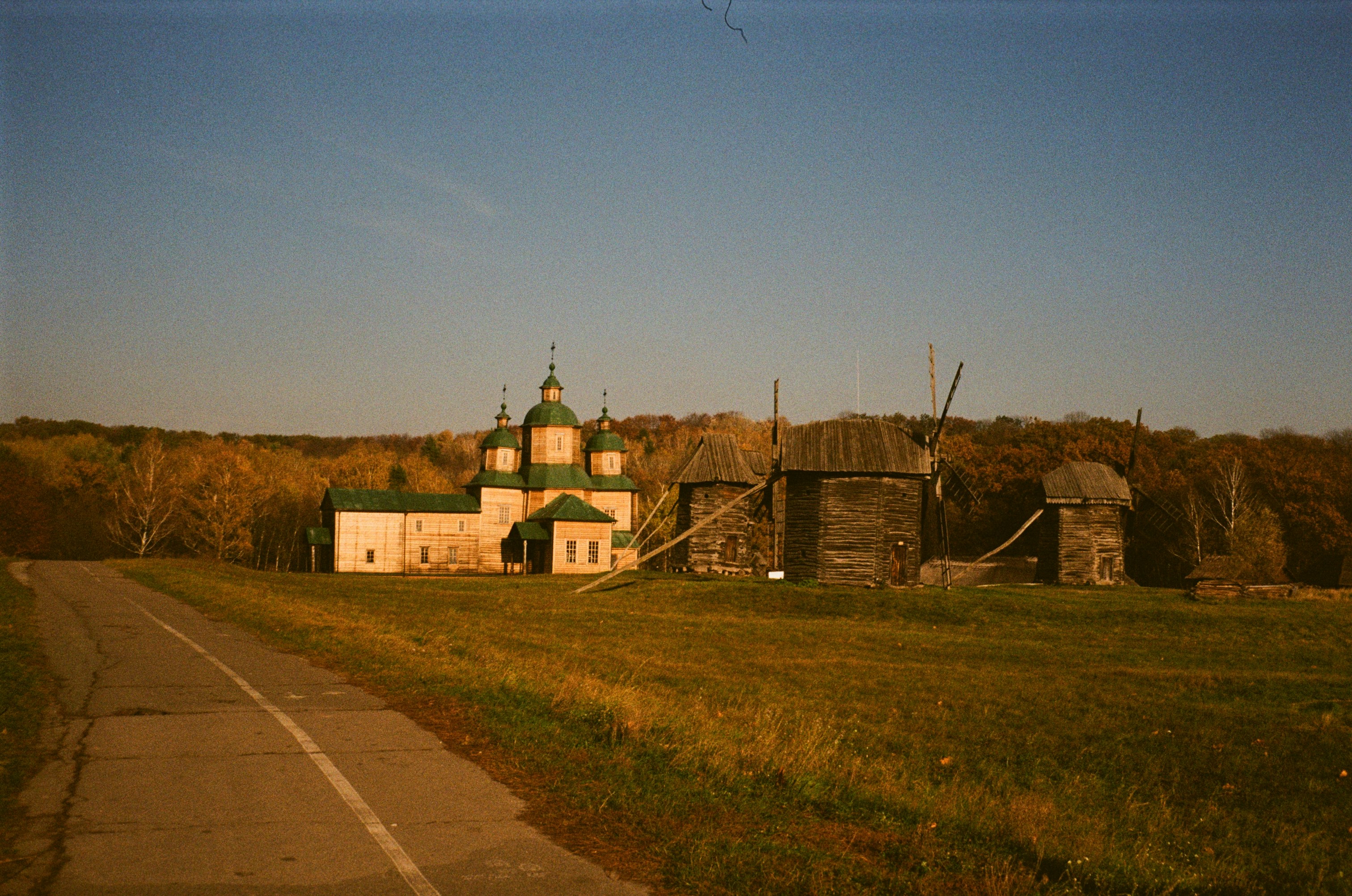 Green domes and weathered barns along a late-afternoon road