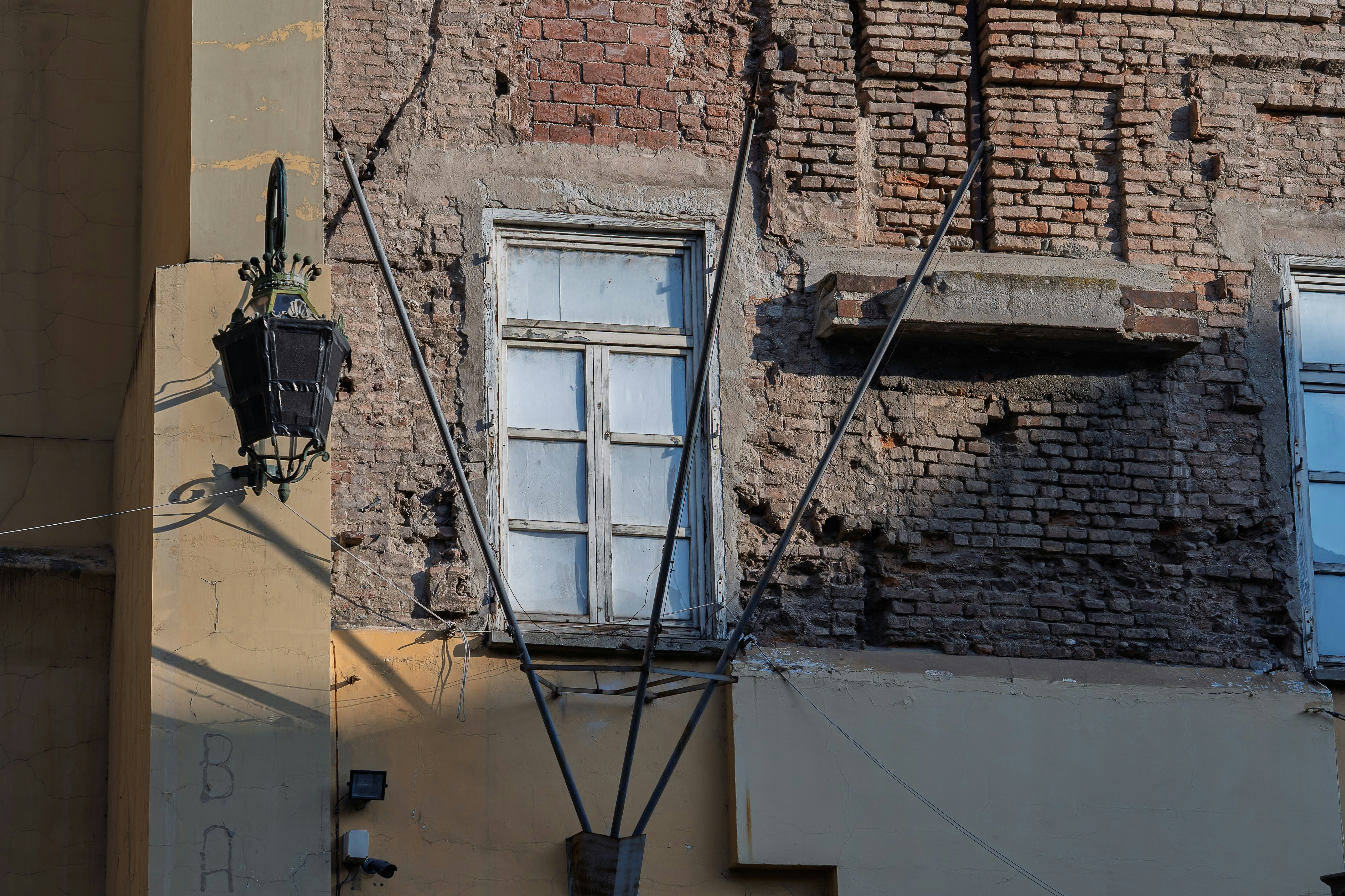 Wired Facade: Bricks, Window, and Cables in the Sun