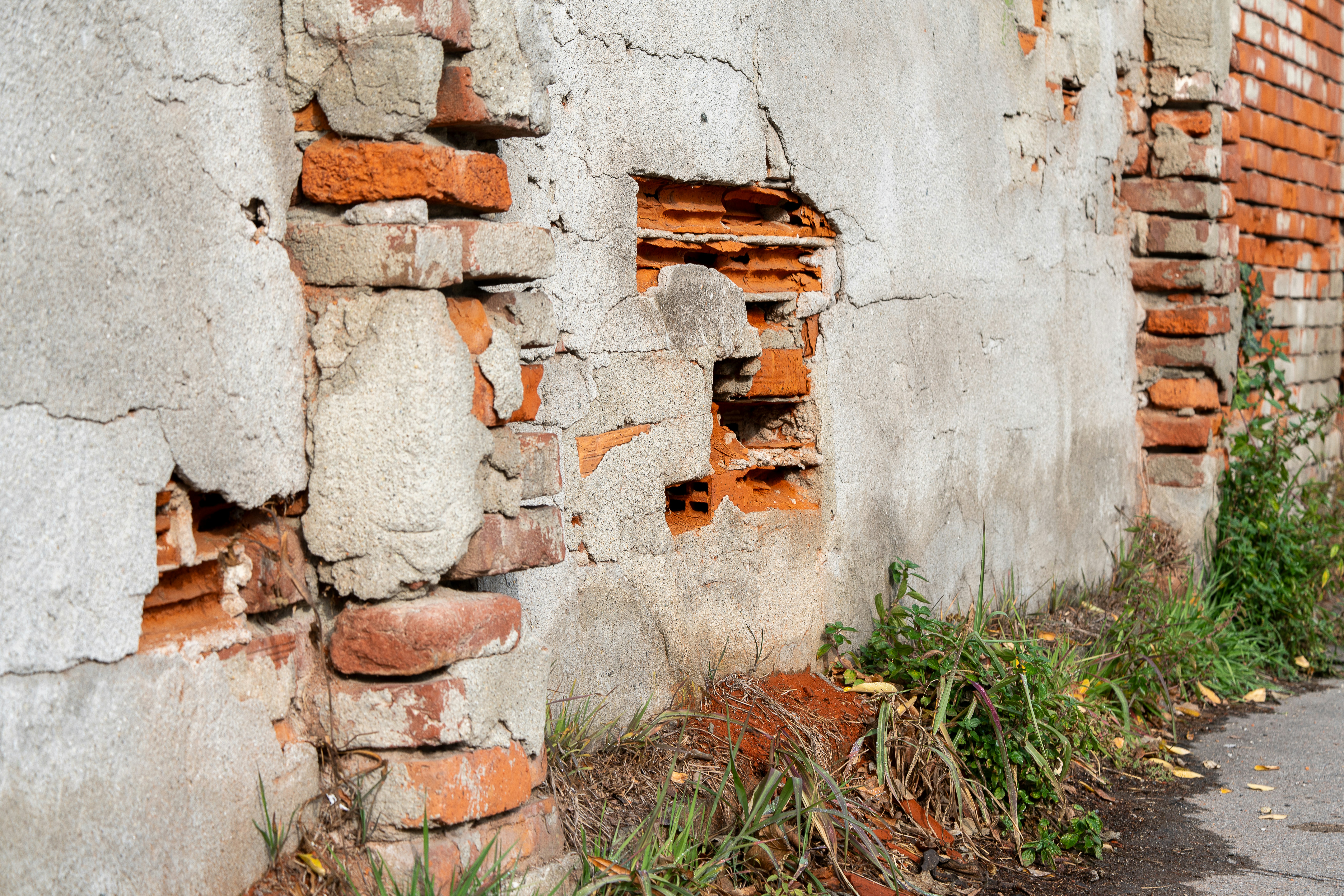 Crumbled Wall with Revealed Brickwork and Grass