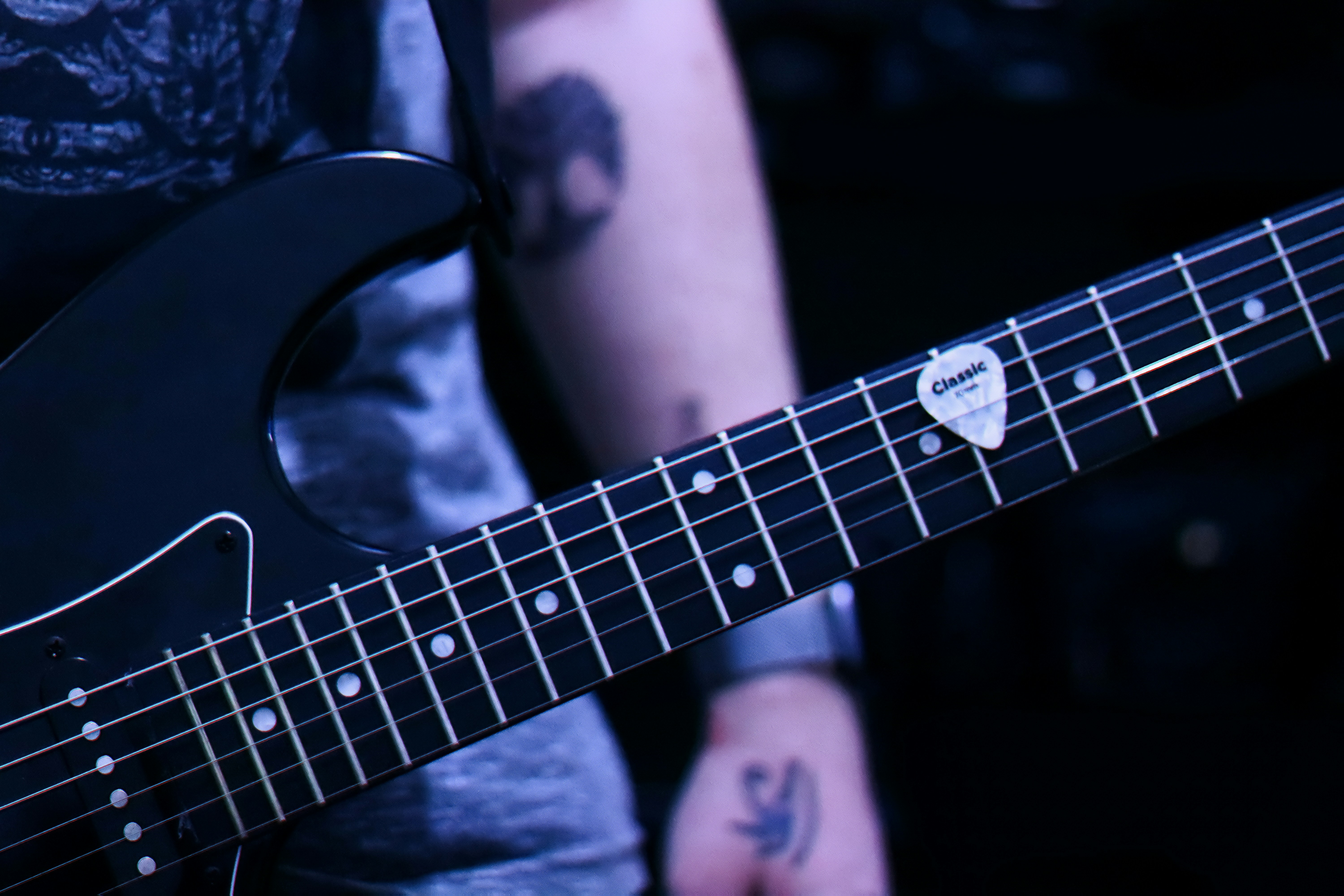 Neck and pickups in focus: a guitarist’s rhythm in blue hue