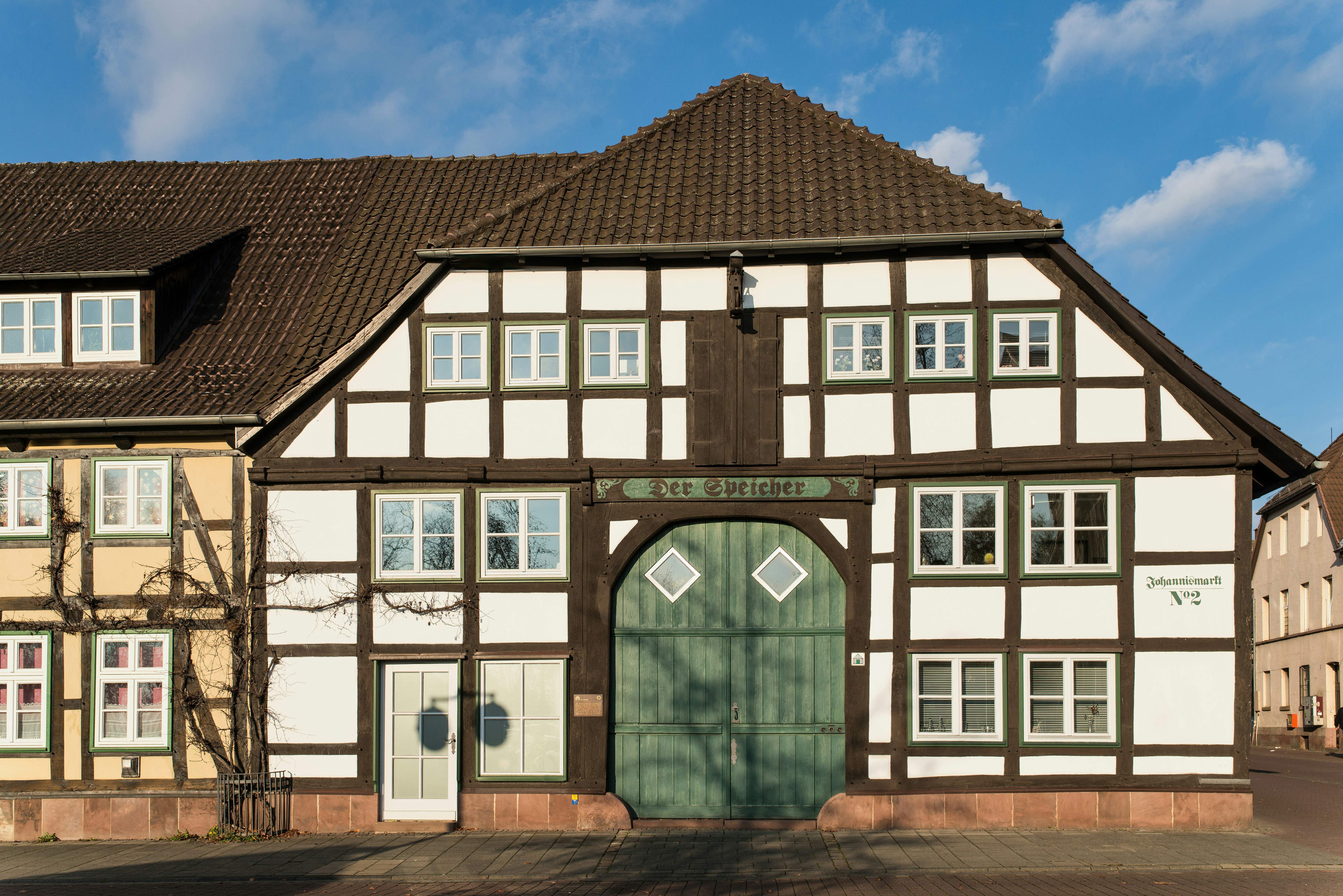 Green Portal under Timbered Facade: A Historic House in Sunlit German Village
