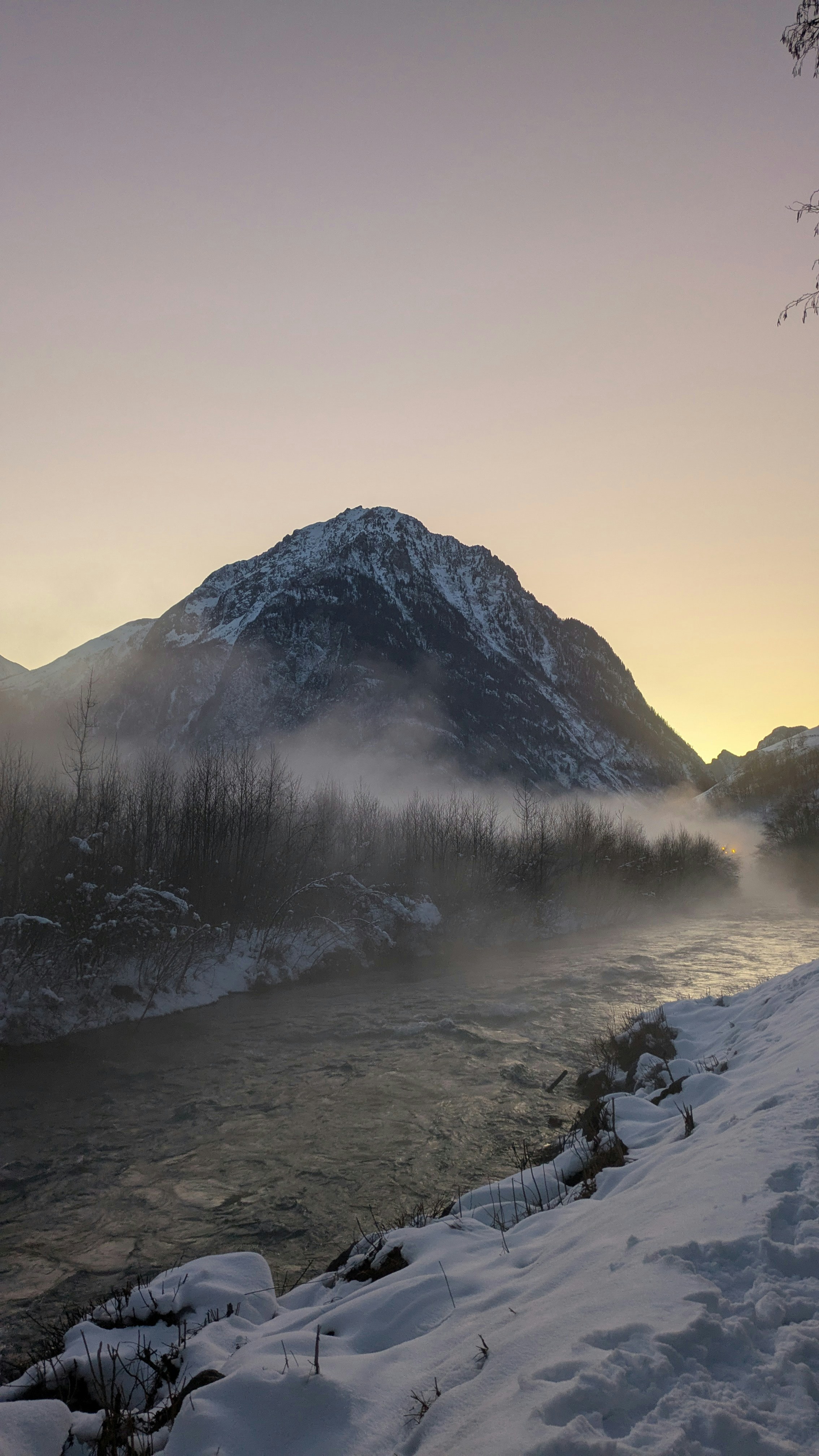 Snowbound Peak at Sunrise Over Misty River Bend