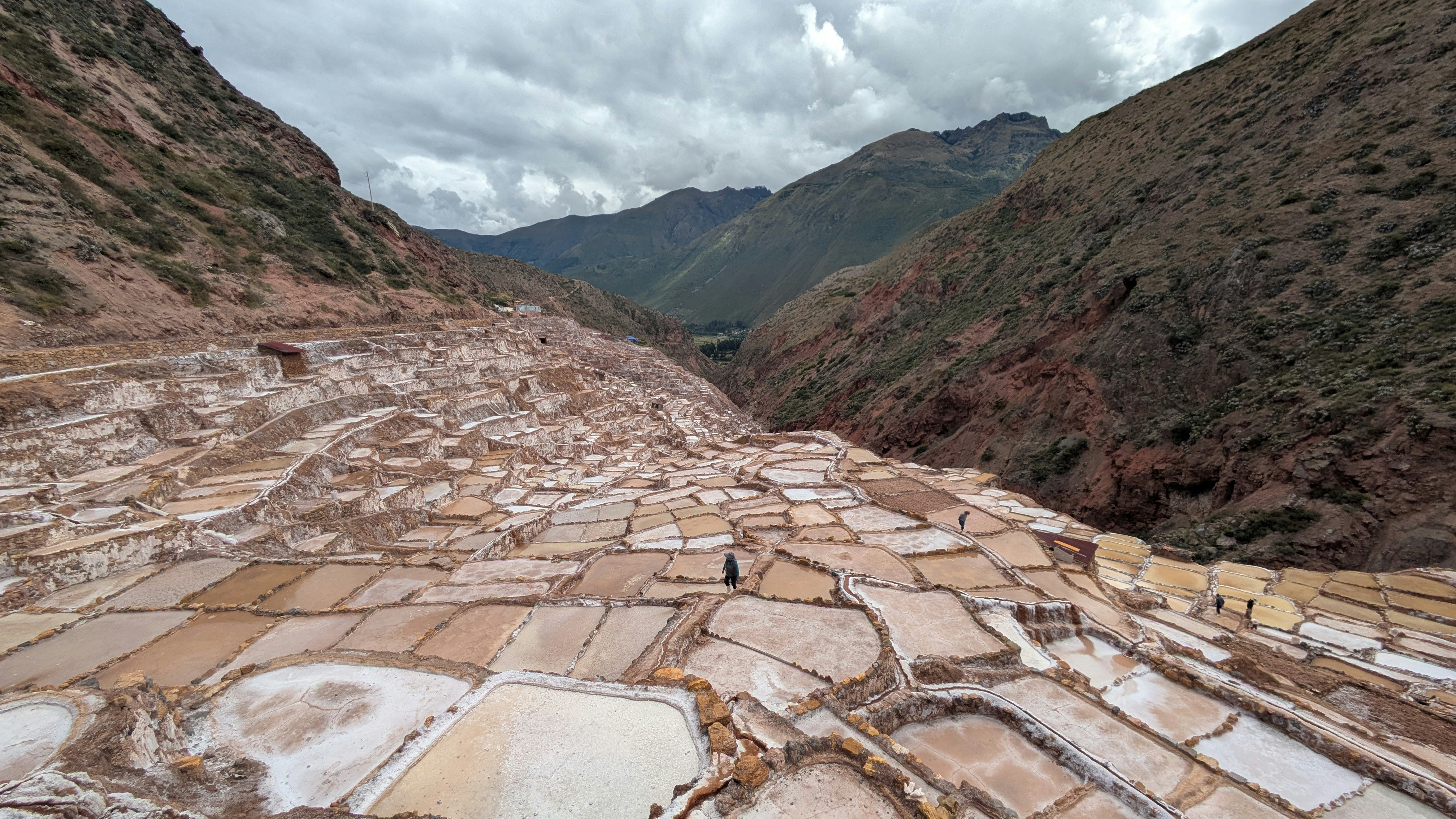 Terraced Salt Flats Under Mountain Veil