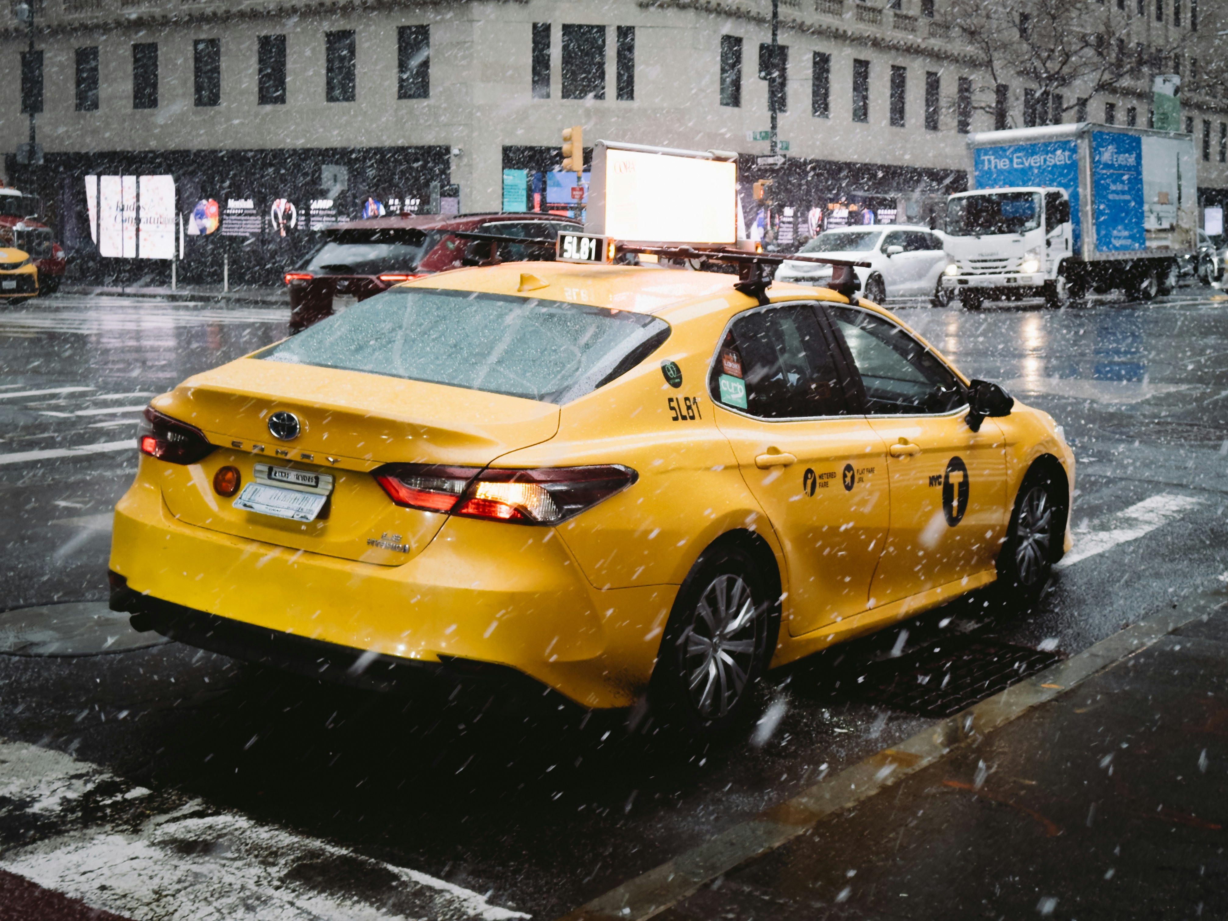 Yellow Cab in Snowy City Traffic